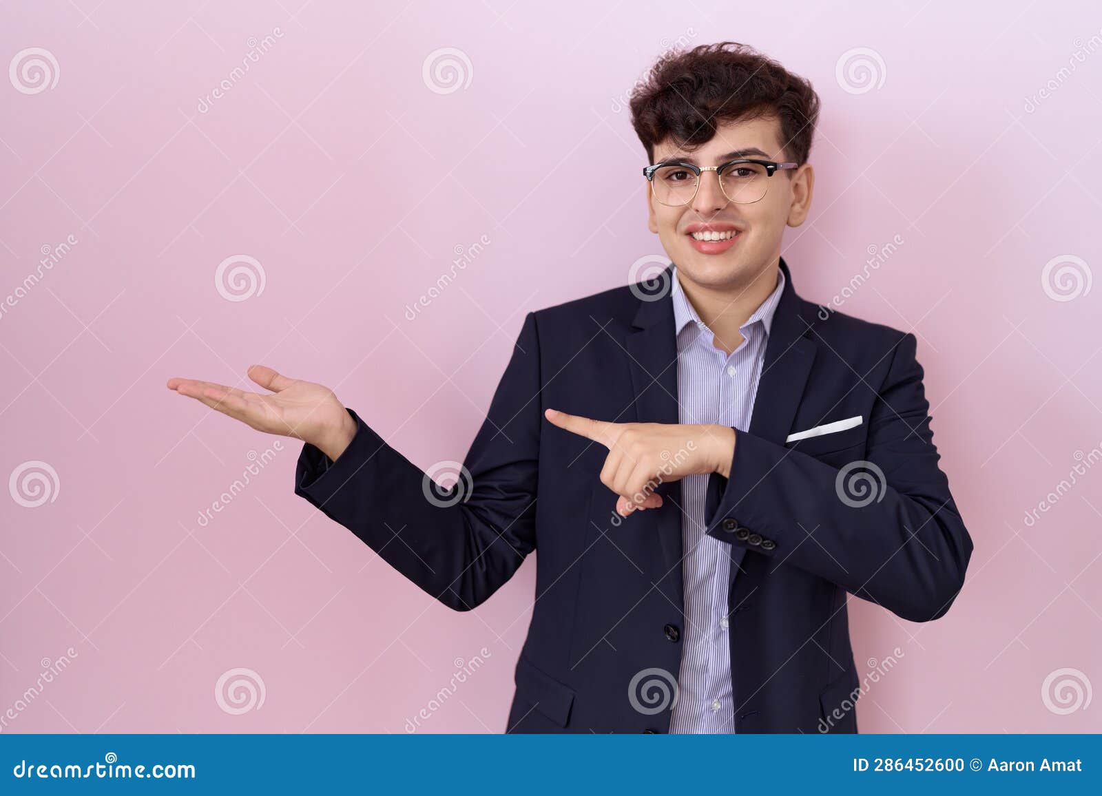 Young Non Binary Man with Beard Wearing Suit and Tie Amazed and Smiling To the Camera while ...