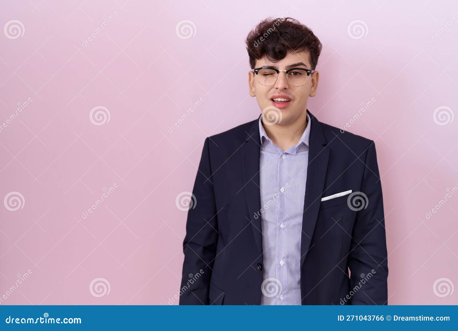 Young Non Binary Man with Beard Wearing Suit and Tie Winking Looking at ...