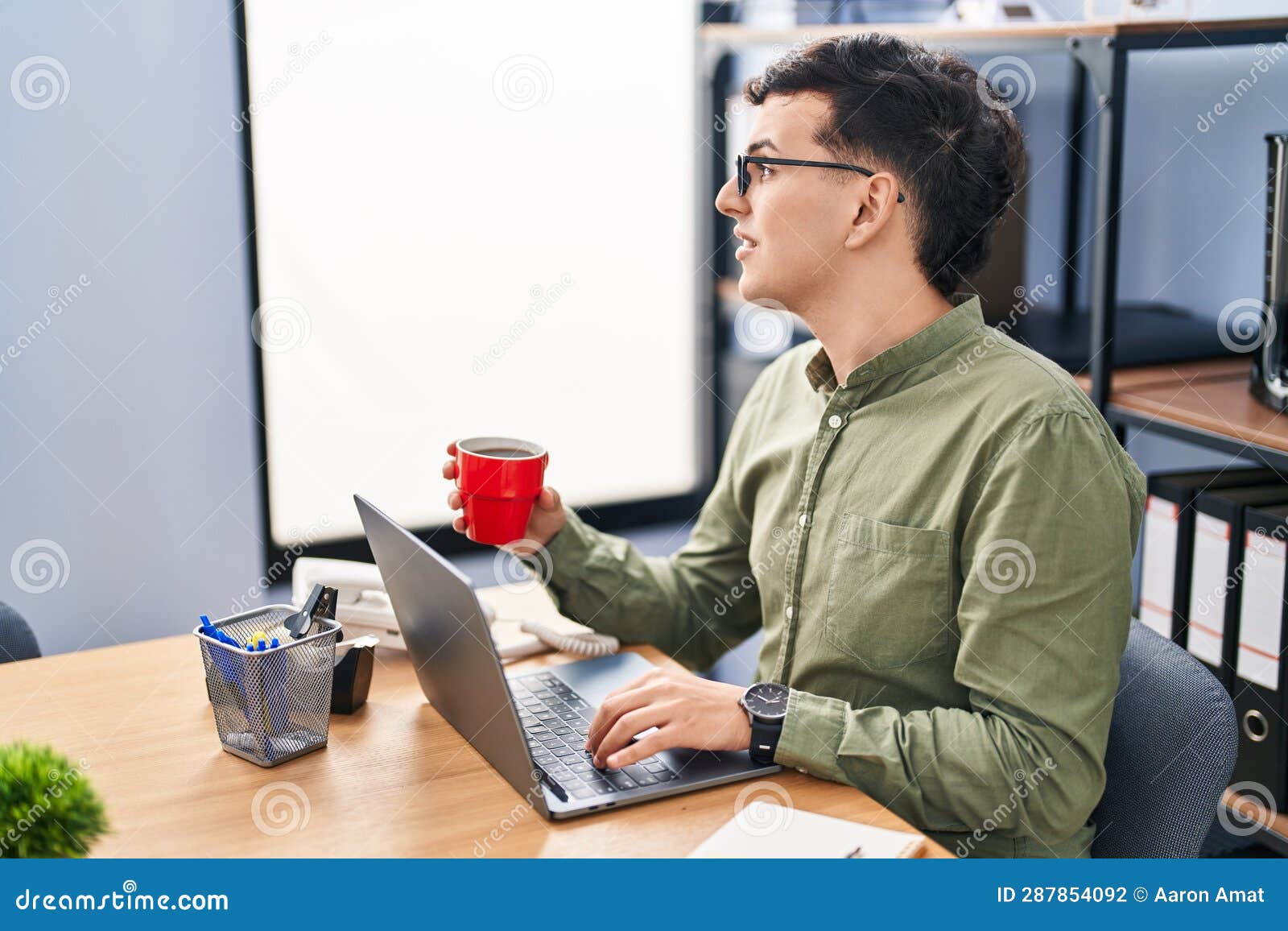 Young Non Binary Man Business Worker Using Laptop Drinking Coffee at ...