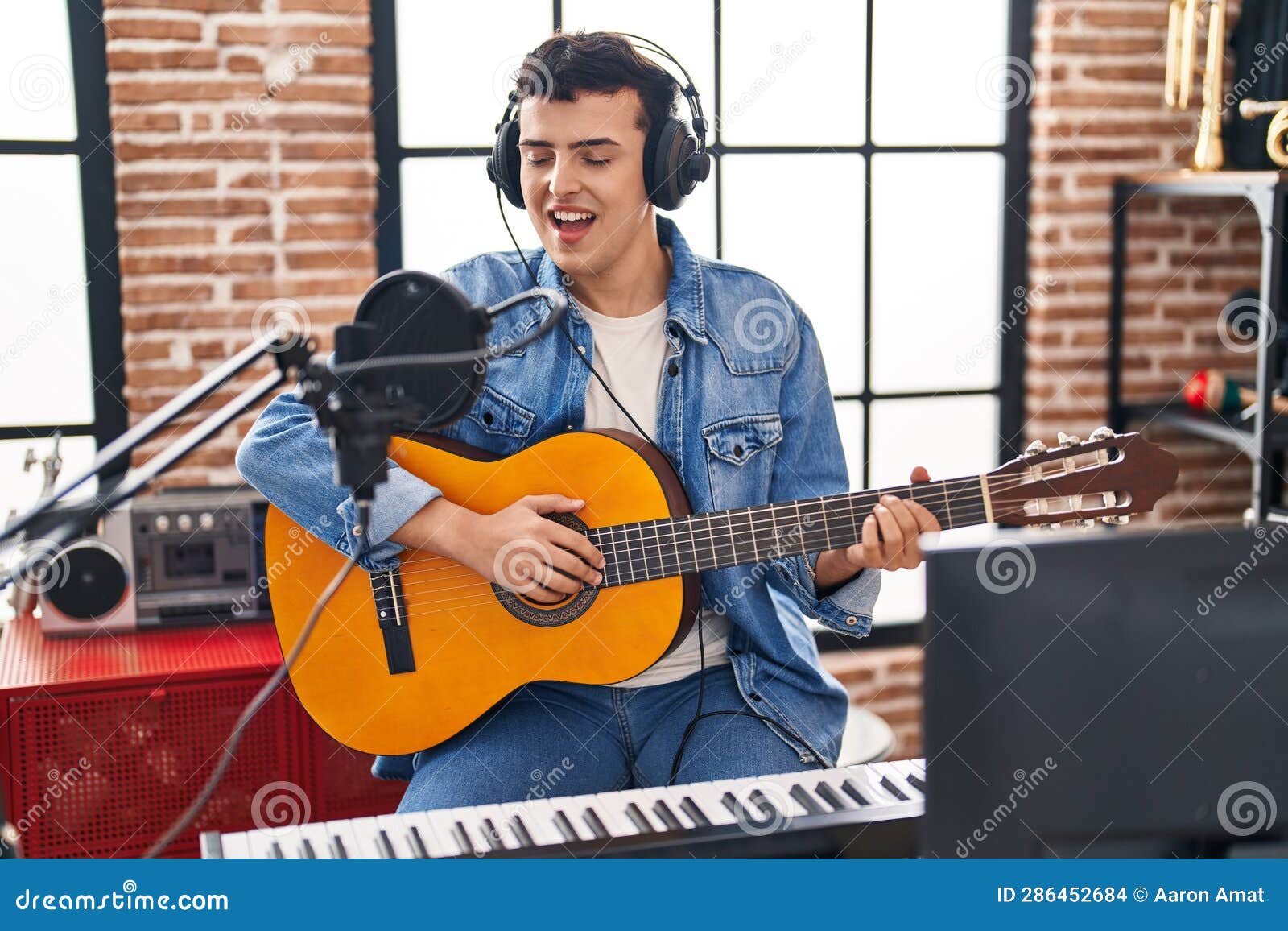 Young Non Binary Man Musician Singing Song Playing Classical Guitar at ...