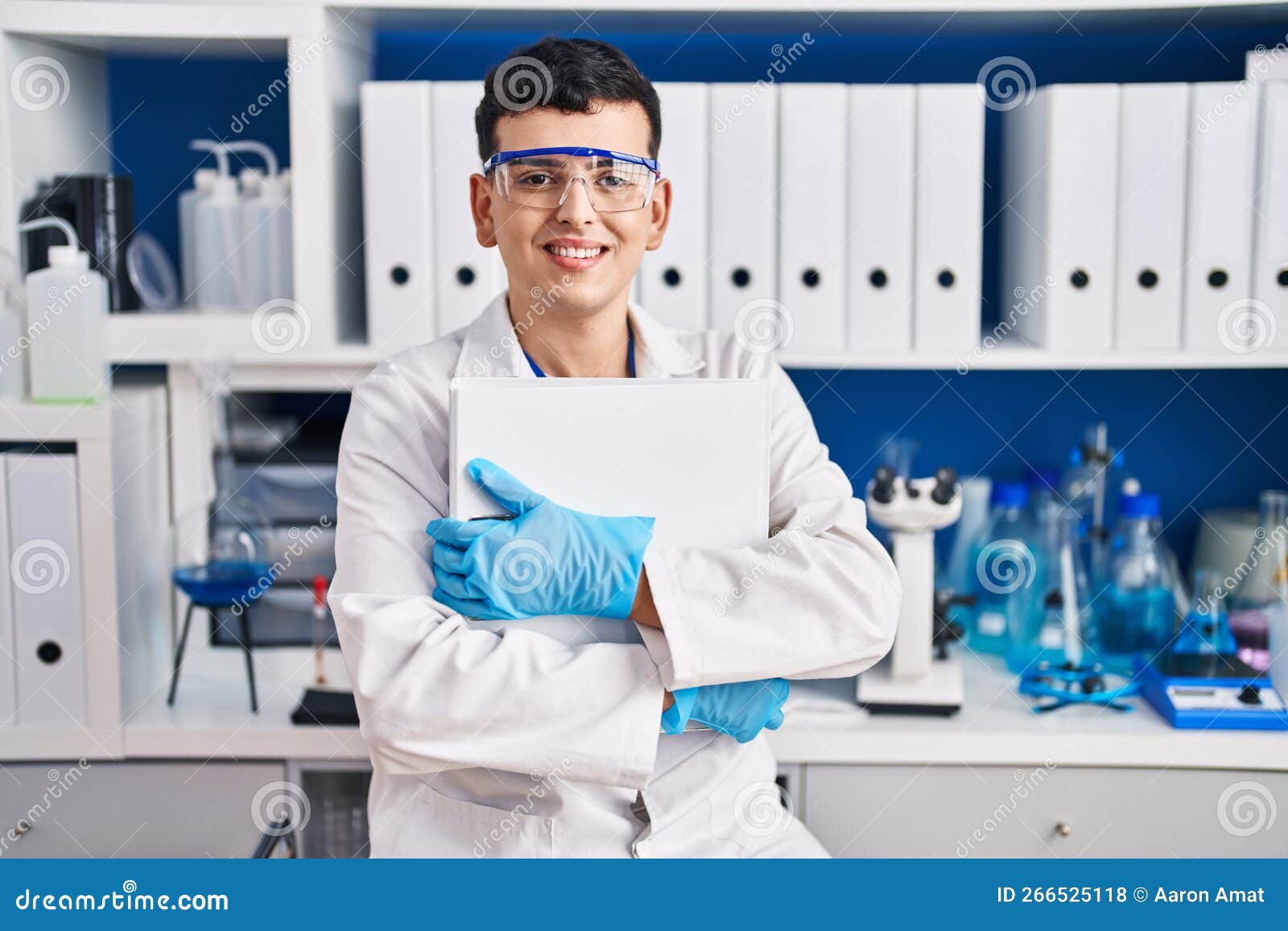 Young Non Binary Man Scientist Smiling Confident Hugging Binder at ...