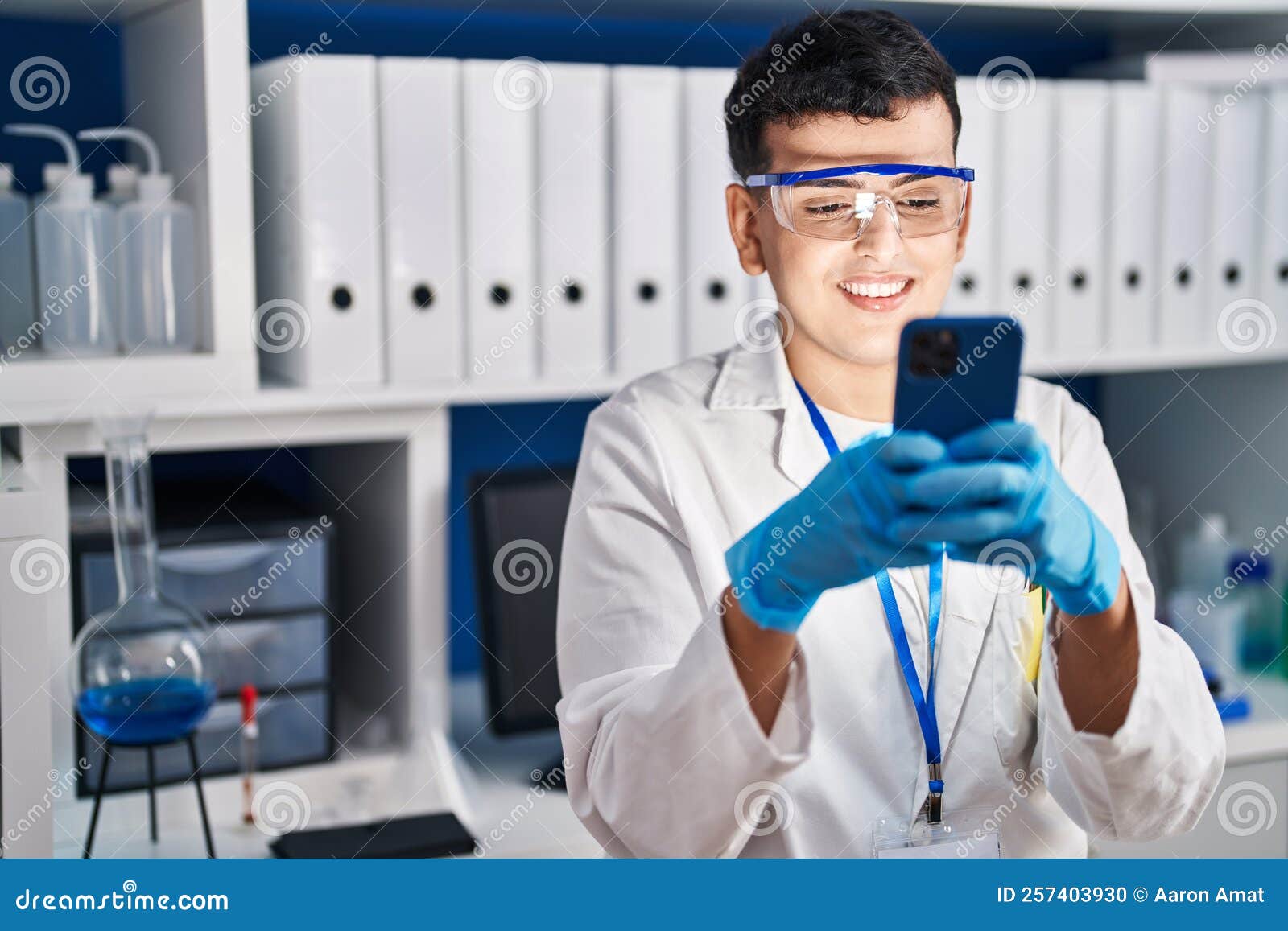 Young Non Binary Man Scientist Smiling Confident Using Smartphone at ...