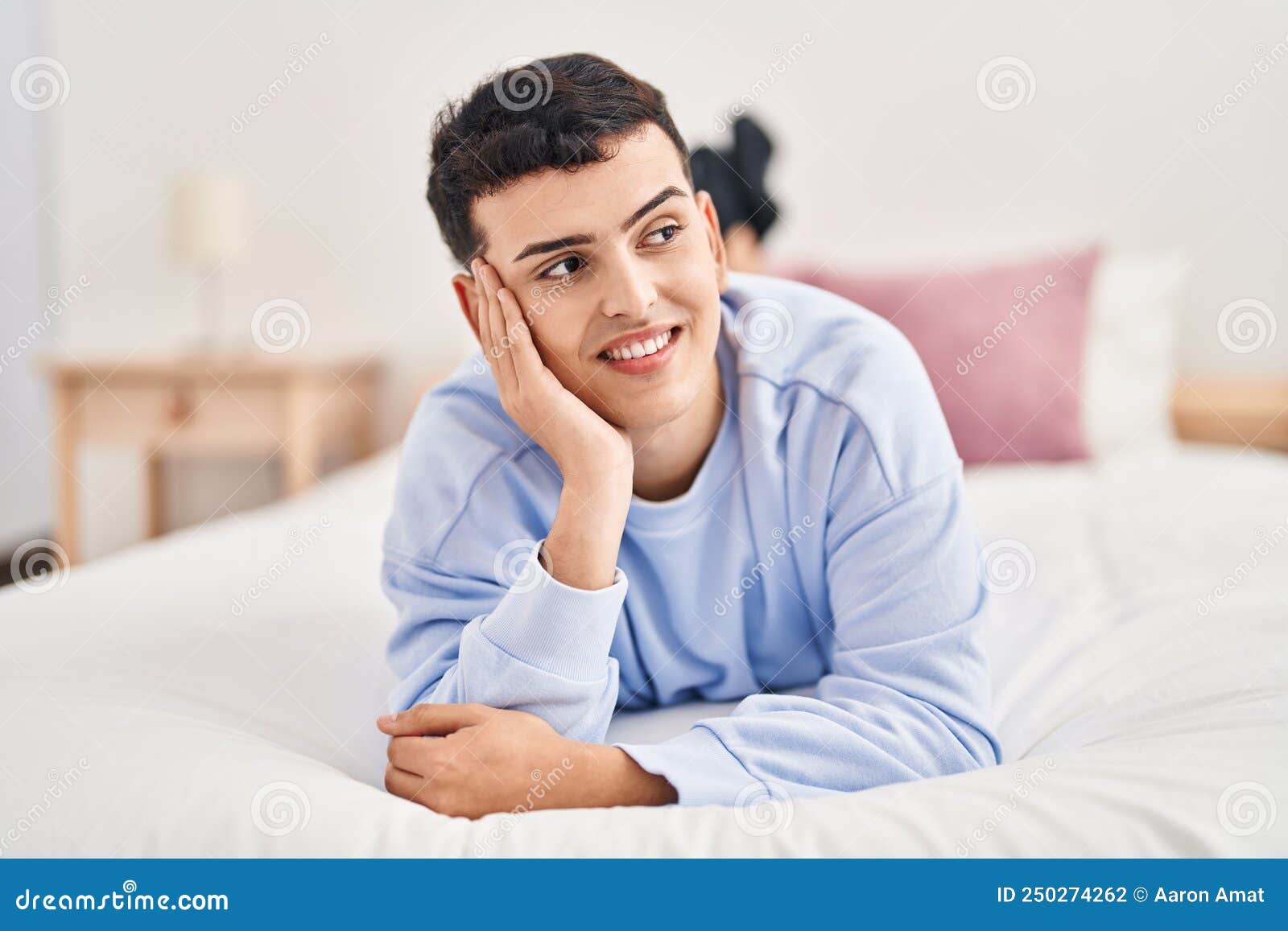 Young Non Binary Man Smiling Confident Lying on Bed Stock Photo - Image ...