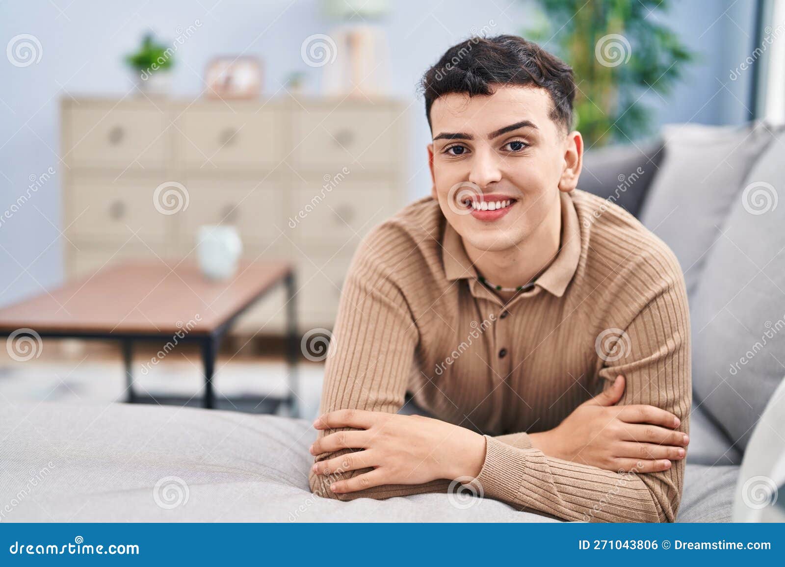 Young Non Binary Man Smiling Confident Lying on Sofa at Home Stock ...