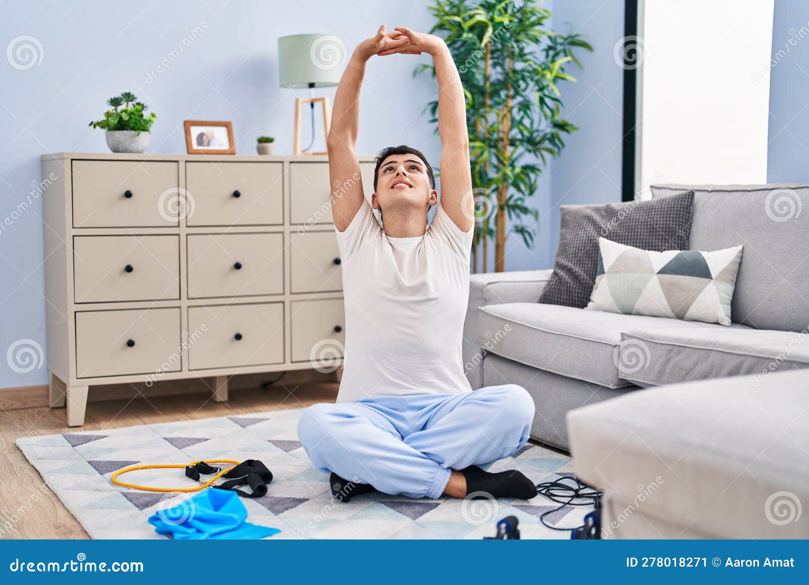 Young Non Binary Man Smiling Confident Stretching Arms at Home Stock ...