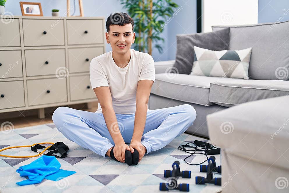 Young Non Binary Man Smiling Confident Stretching Legs at Home Stock ...