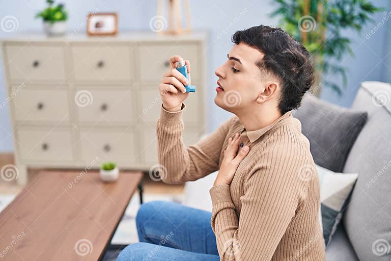 Young Non Binary Man Using Inhaler Sitting on Sofa at Home Stock Image - Image of resting ...