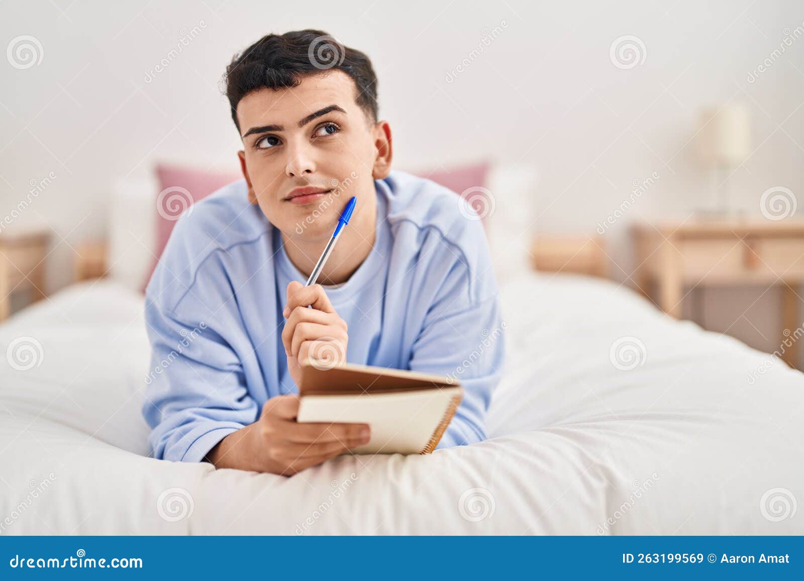 Young Non Binary Man Writing on Notebook Lying on Bed Stock Image ...
