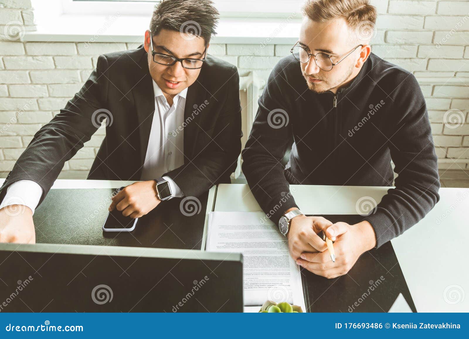 Young Office Worker Sitting at Desk, Using Computer. Two Business Man ...