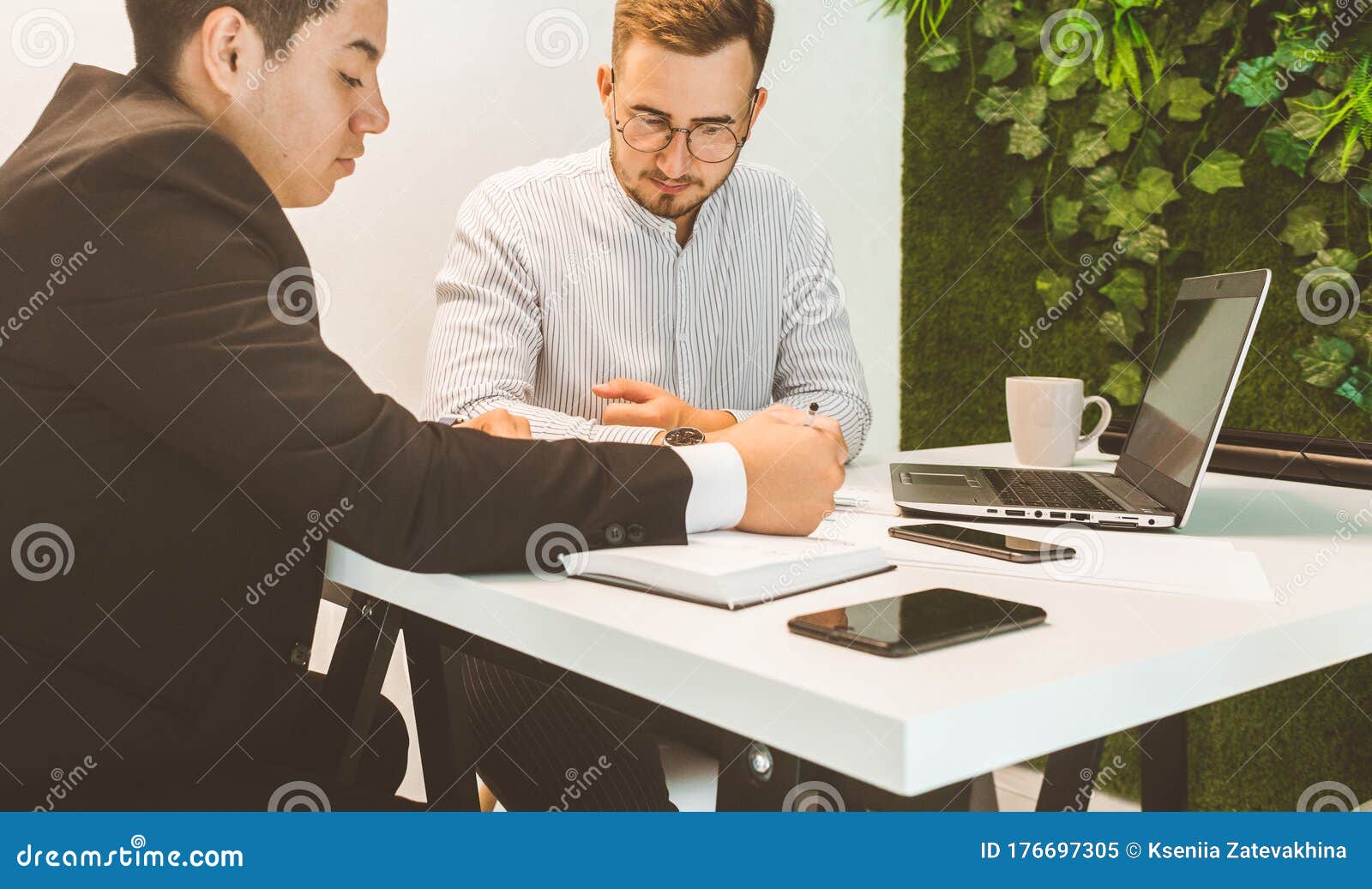 Young Office Worker Sitting at Desk, Using Computer. Two Business Man ...