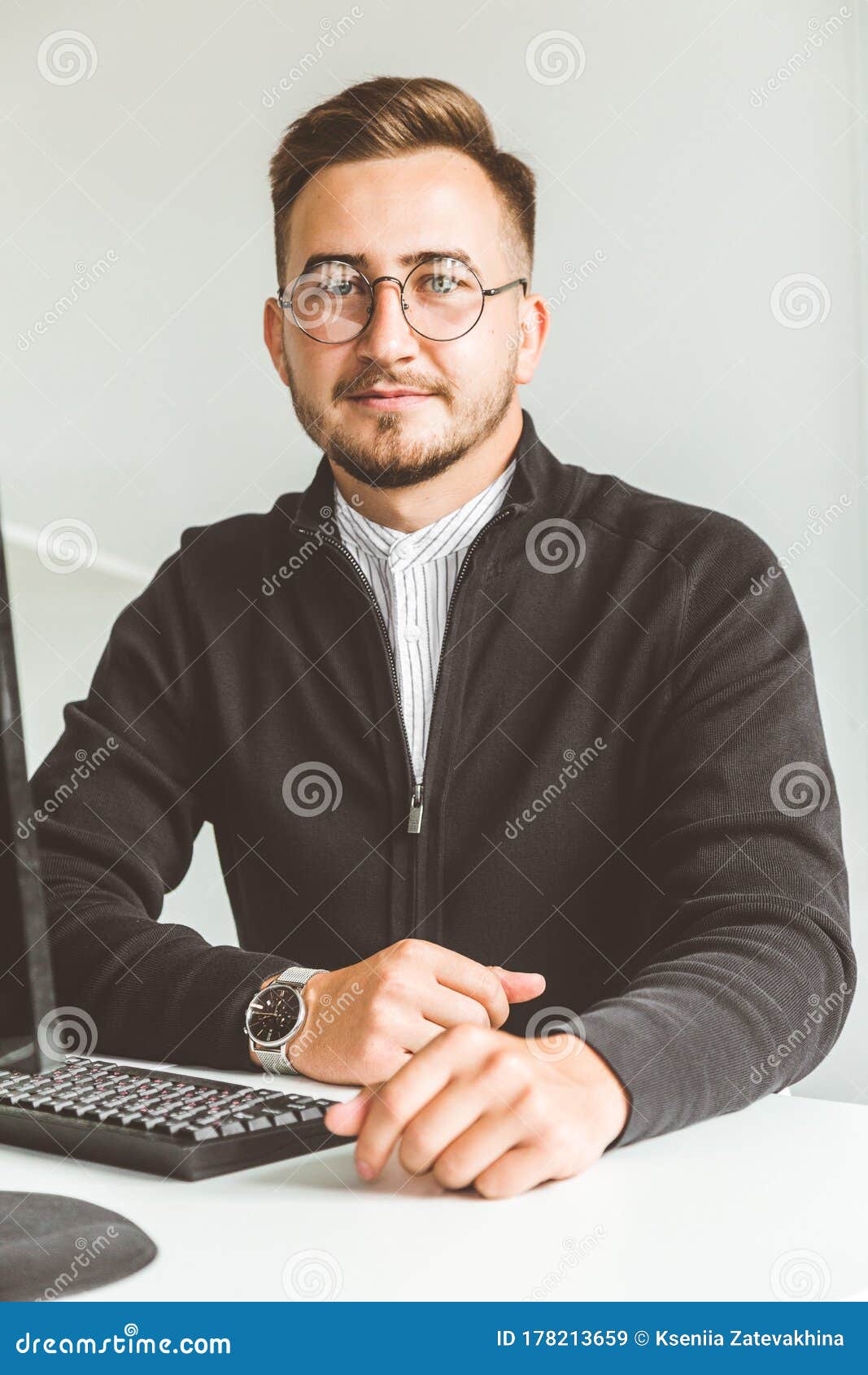Young Office Worker Sitting at Desk, Using Computer. Two Business Man ...