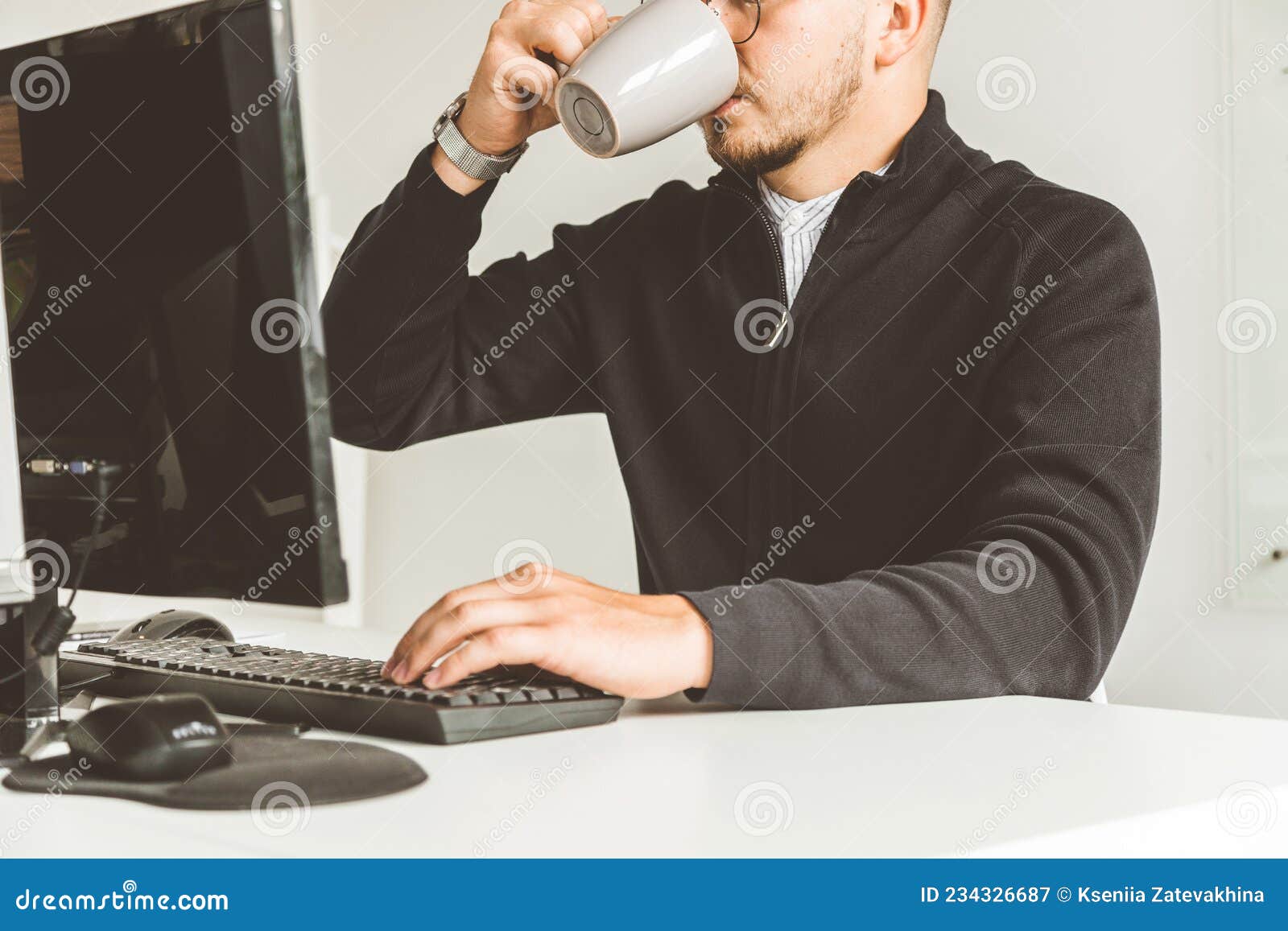 Young Office Worker Sitting at Desk, Using Computer. Two Business Man ...