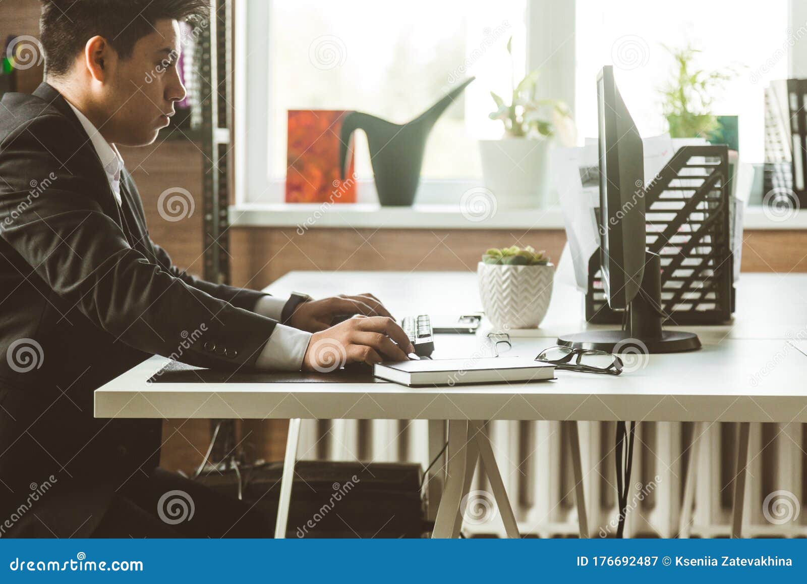 Young Office Worker Sitting at Desk, Using Computer. Two Business Man ...