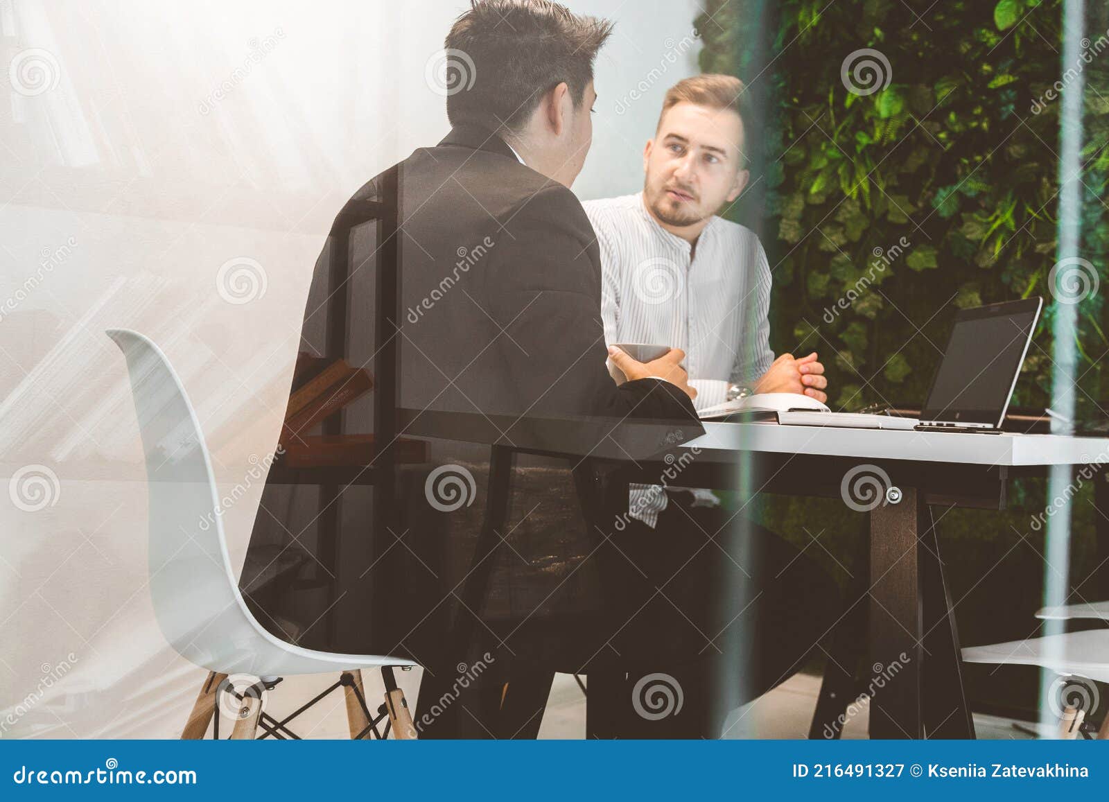 Young Office Worker Sitting at Desk, Using Computer. Two Business Man ...