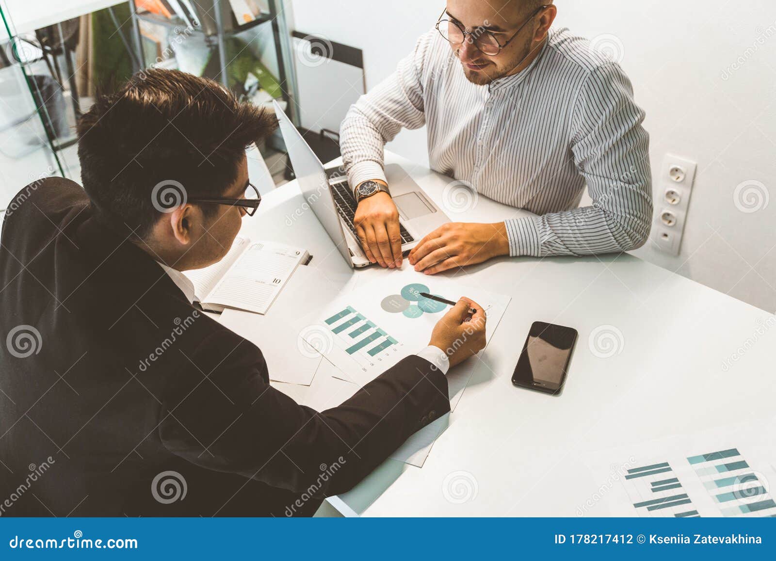 Young Office Worker Sitting at Desk, Using Computer. Two Business Man ...