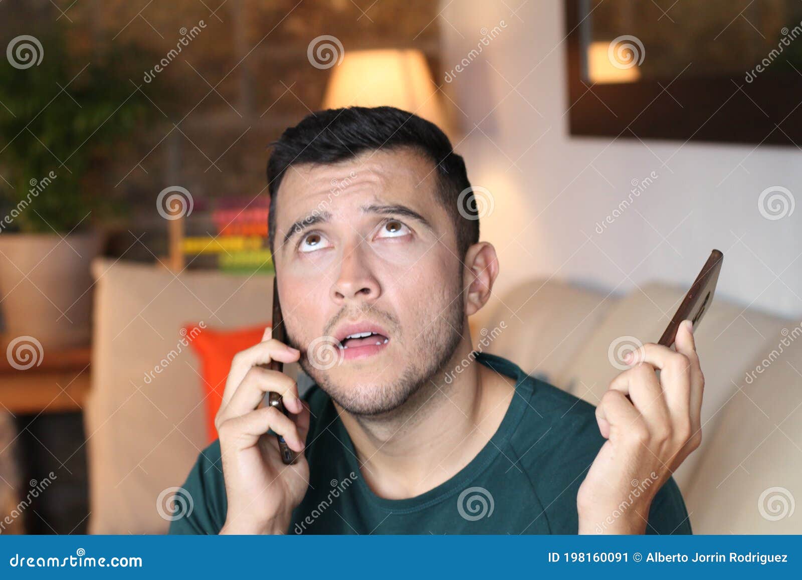 Young Overwhelmed Man Using Two Cellphones Stock Image - Image of ...