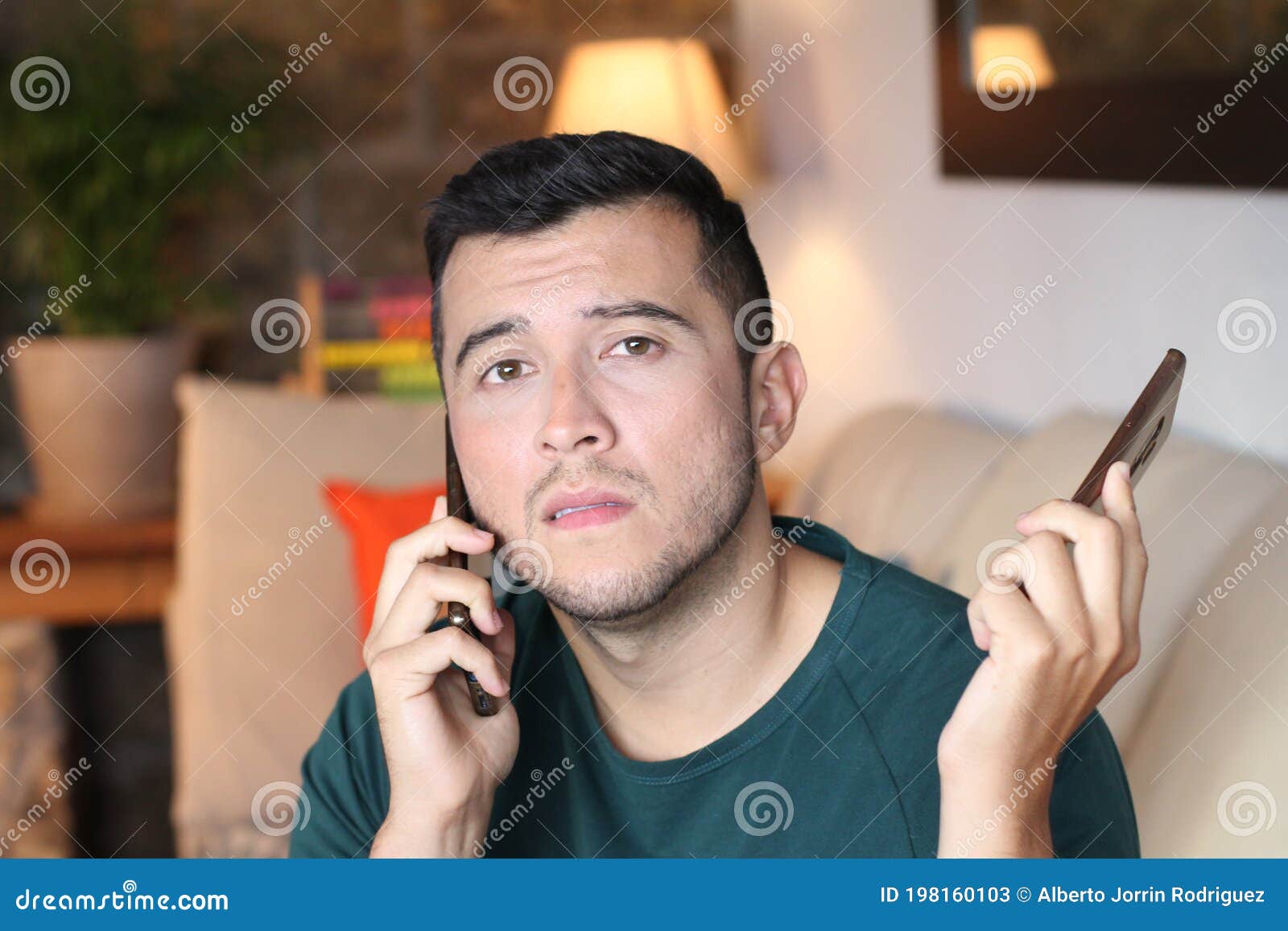 Young Overwhelmed Man Using Two Cellphones Stock Image - Image of ...