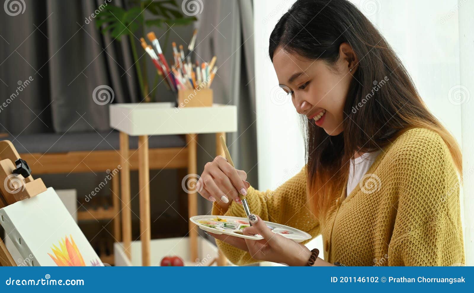 A Young Painter Smiling and Working on Painting. Stock Photo - Image of ...
