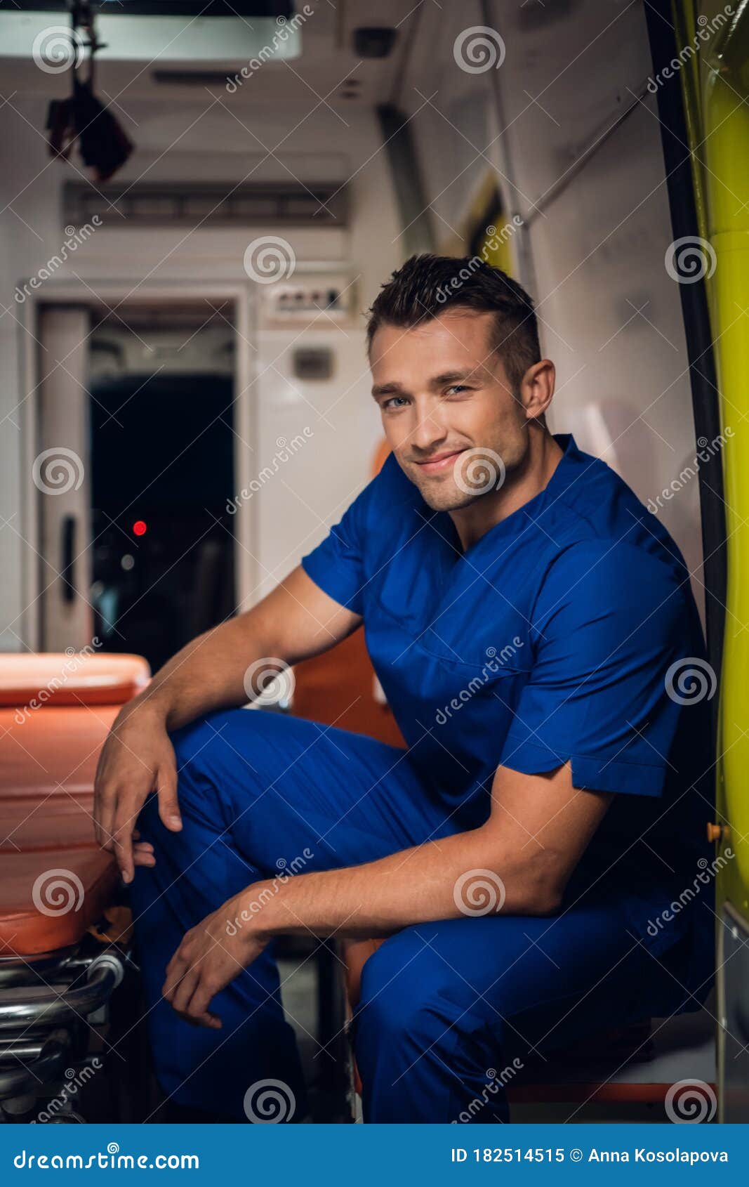 Young Paramedic in a Uniform Sitting in the Back of an Ambulance with a ...