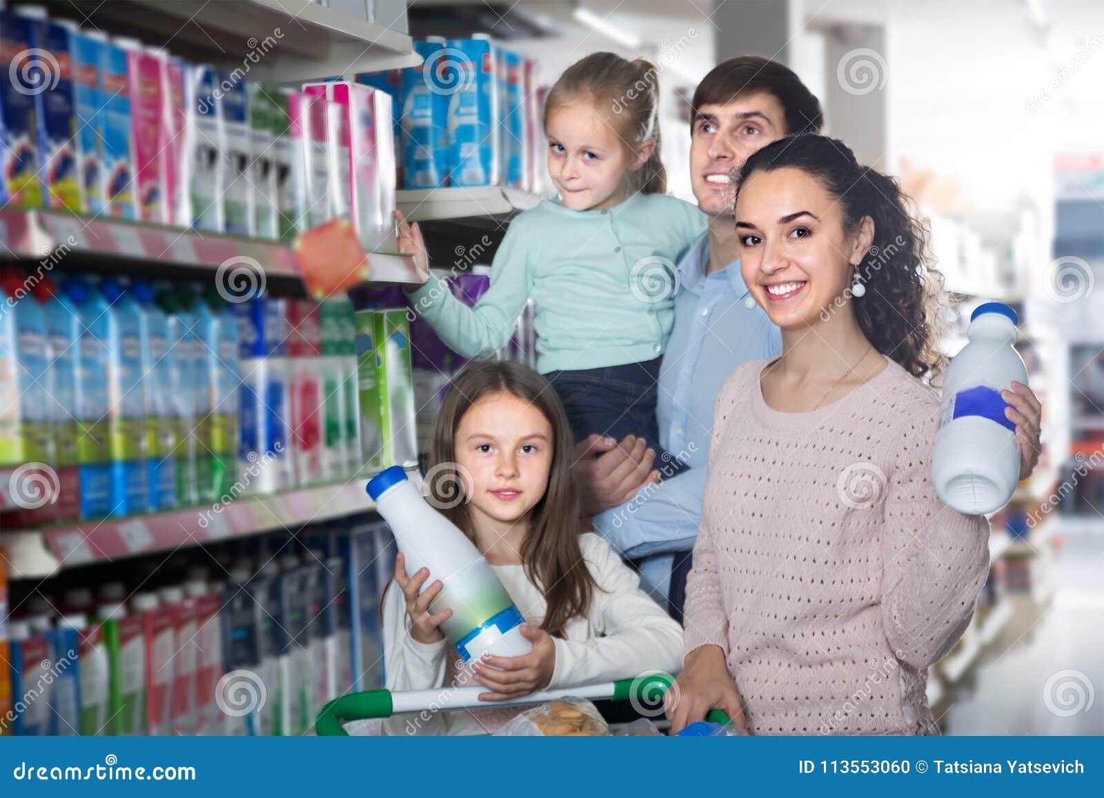 Young Parents with Two Kids Holding Purchases in Store Stock Photo ...
