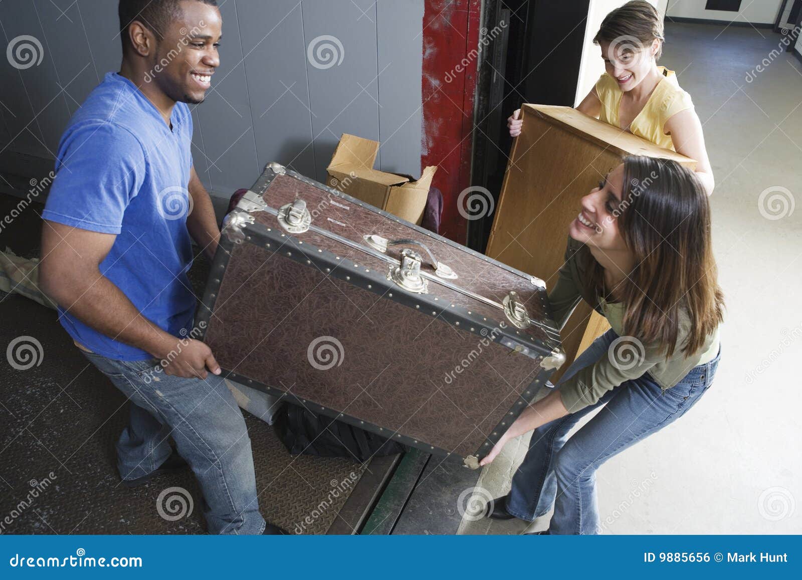 Young People Carrying Heavy Box on Moving Day. Stock Photo - Image of ...