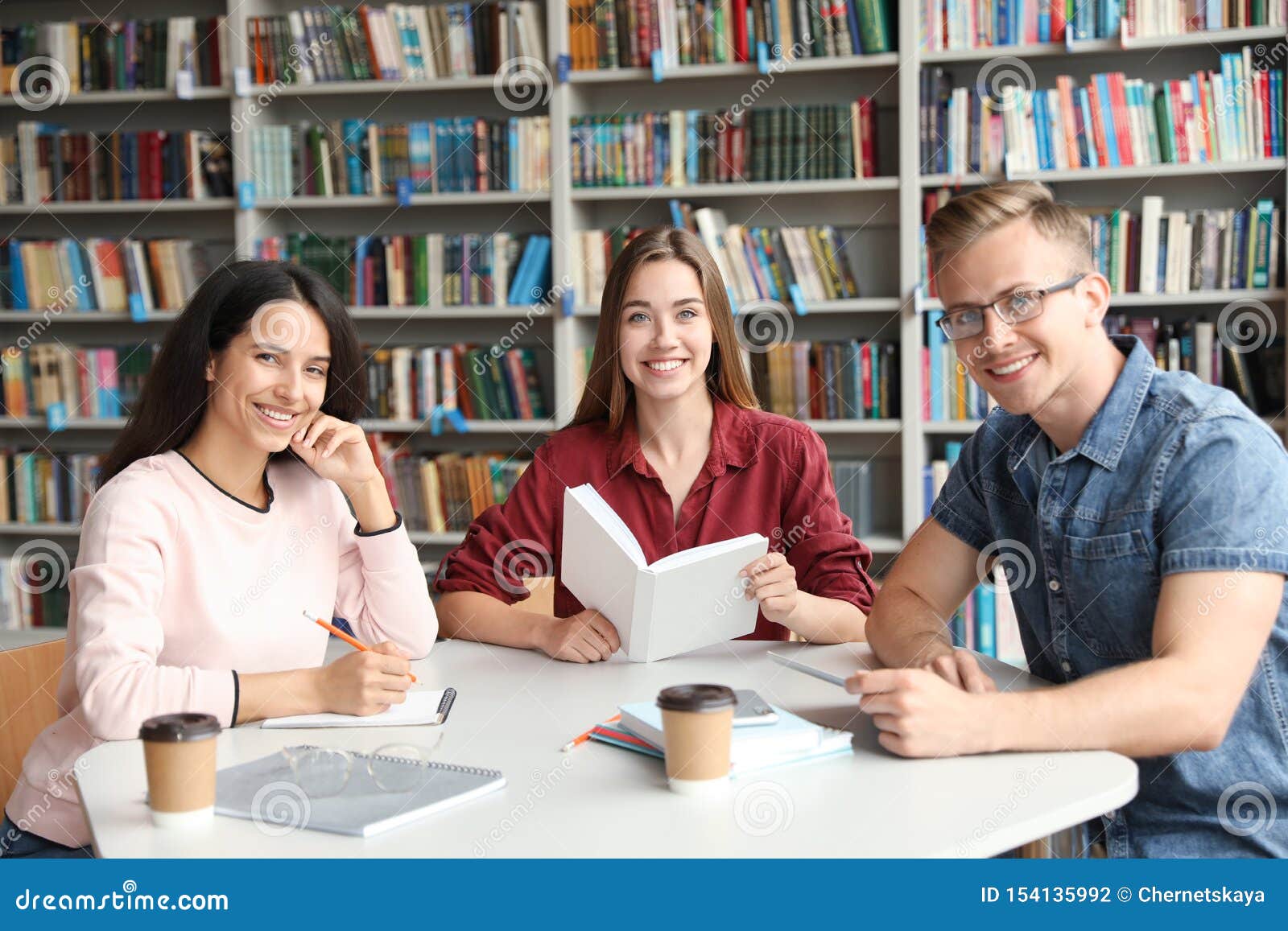 Young People Discussing Group Project at Table in Stock Photo - Image ...