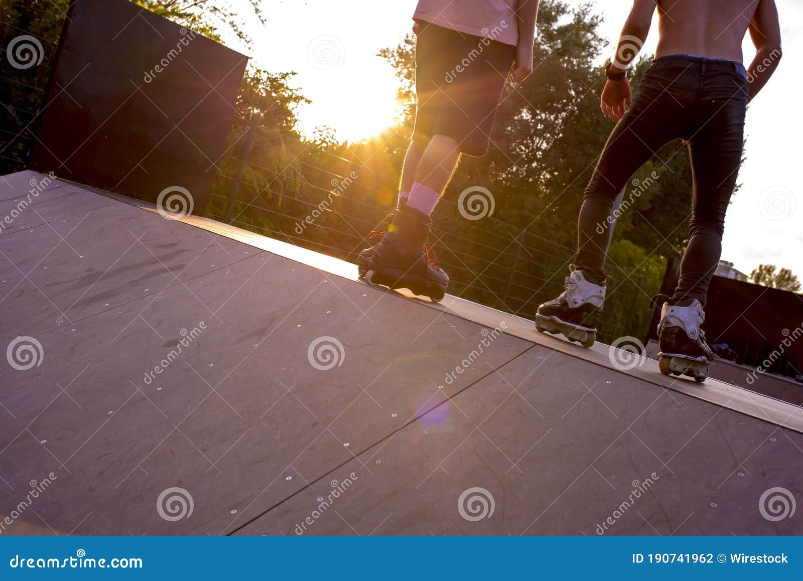 Young People Rollerblading in a Park Surrounded by Trees Under the ...