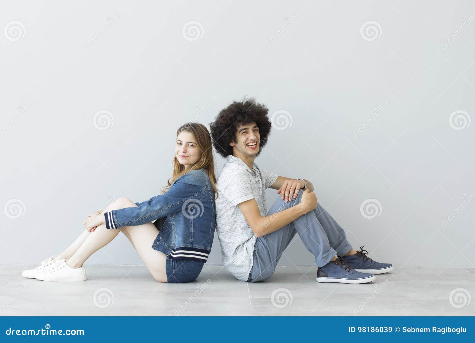 Young People Sitting Back To Back Stock Image - Image of smile, friends ...