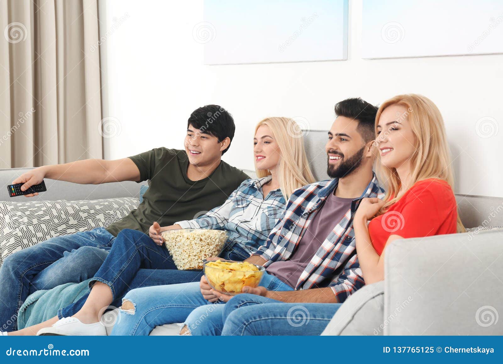 Young People with Snacks Watching TV on Sofa Stock Image - Image of ...