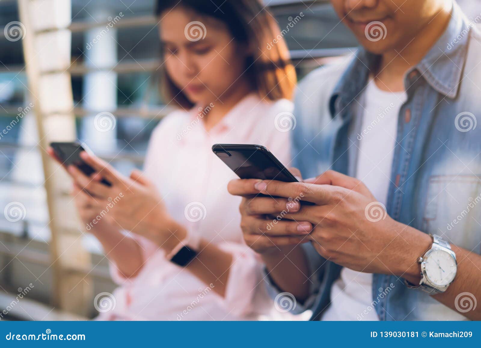 Young People are Using Smartphone and Smiling while Sitting on Free ...