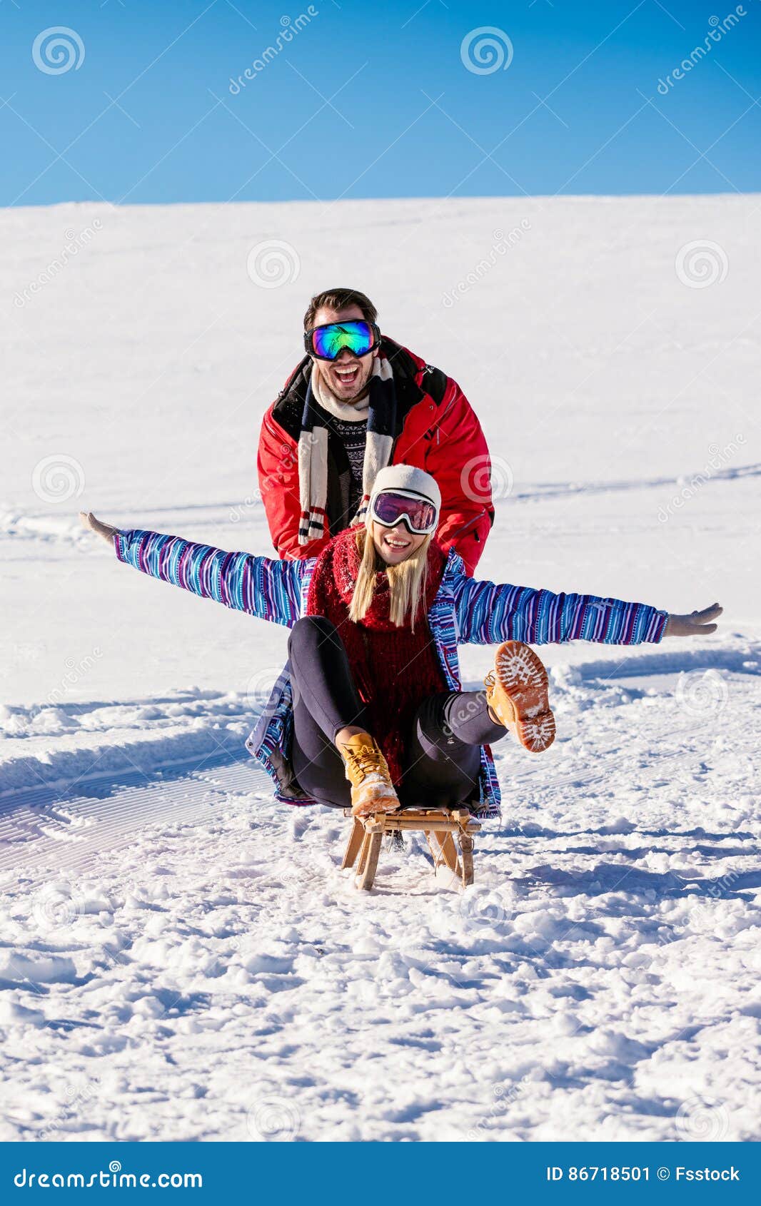 Young Playful Couple Having Fun Sledging Down Snow Covered Hill Stock ...