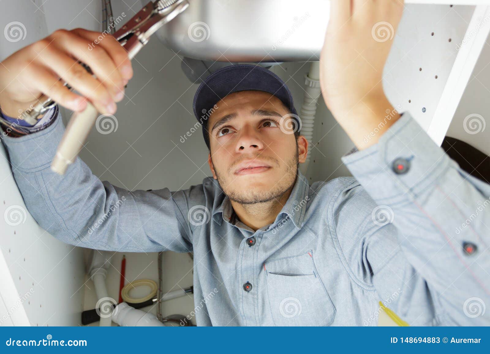 Young plumber fixing sink stock image. Image of sink - 148694883