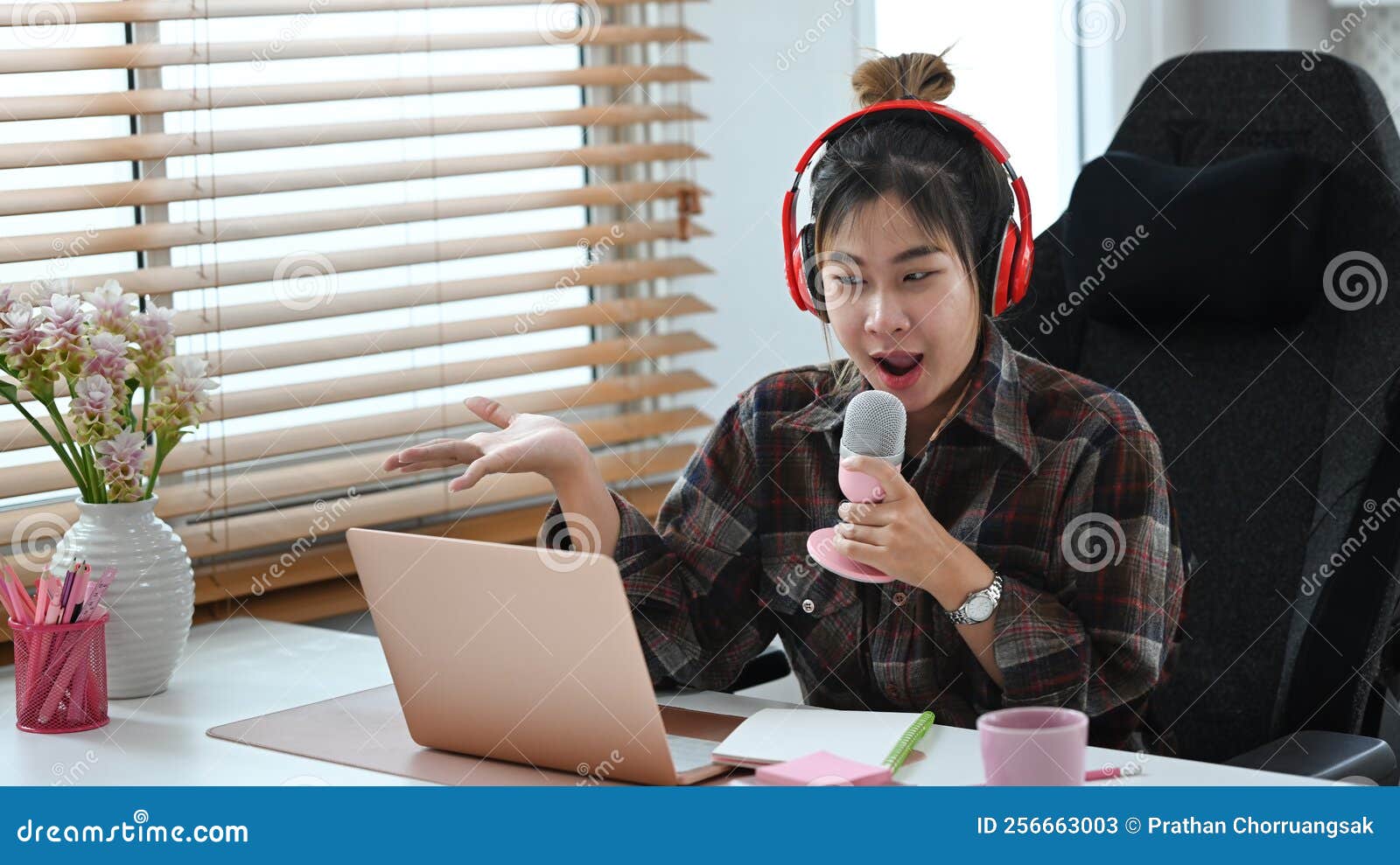 Young Podcaster Using a Microphone and Laptop Computer Recording Audio ...