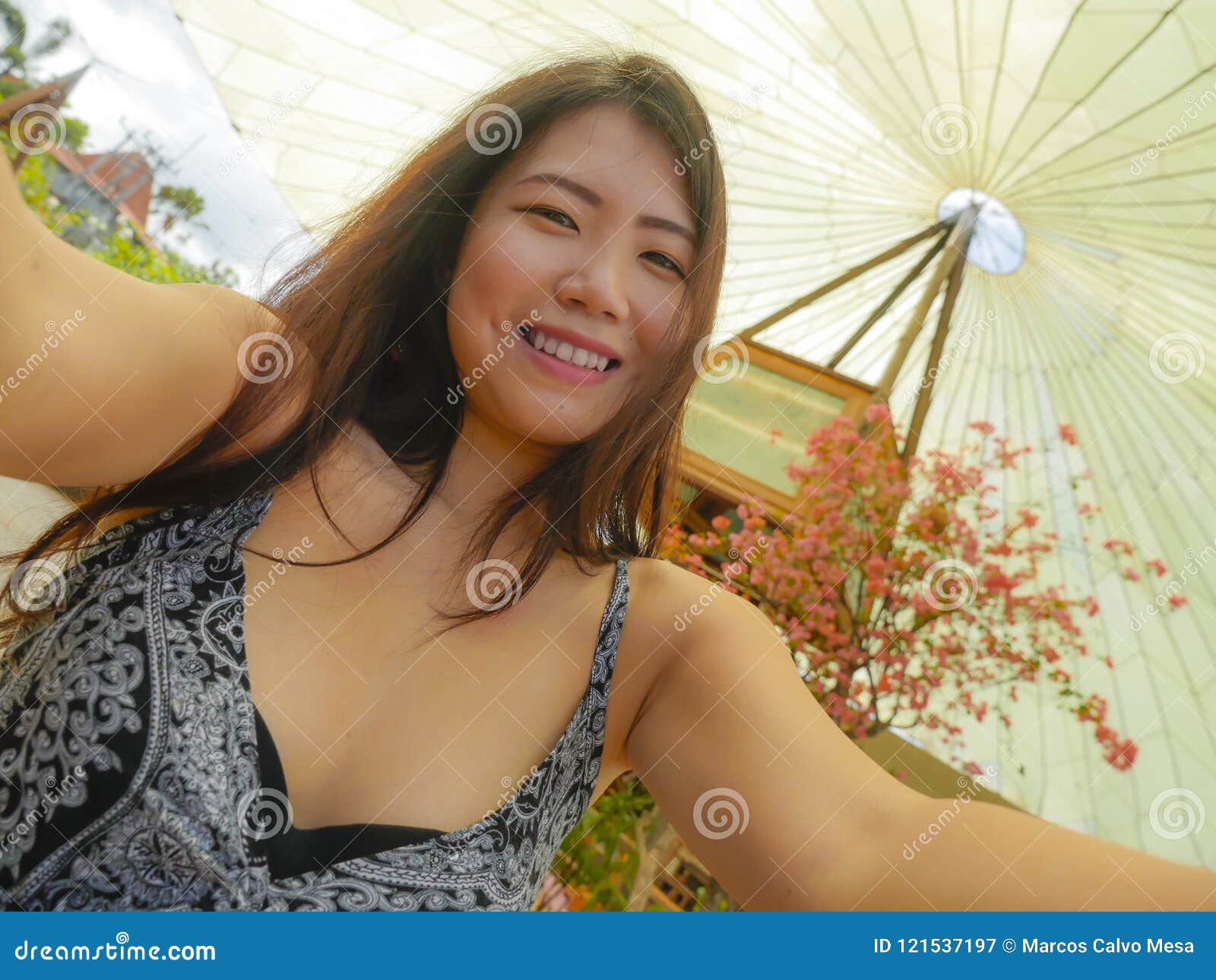 Young Pretty And Happy Asian Chinese Tourist Woman Smiling Holding