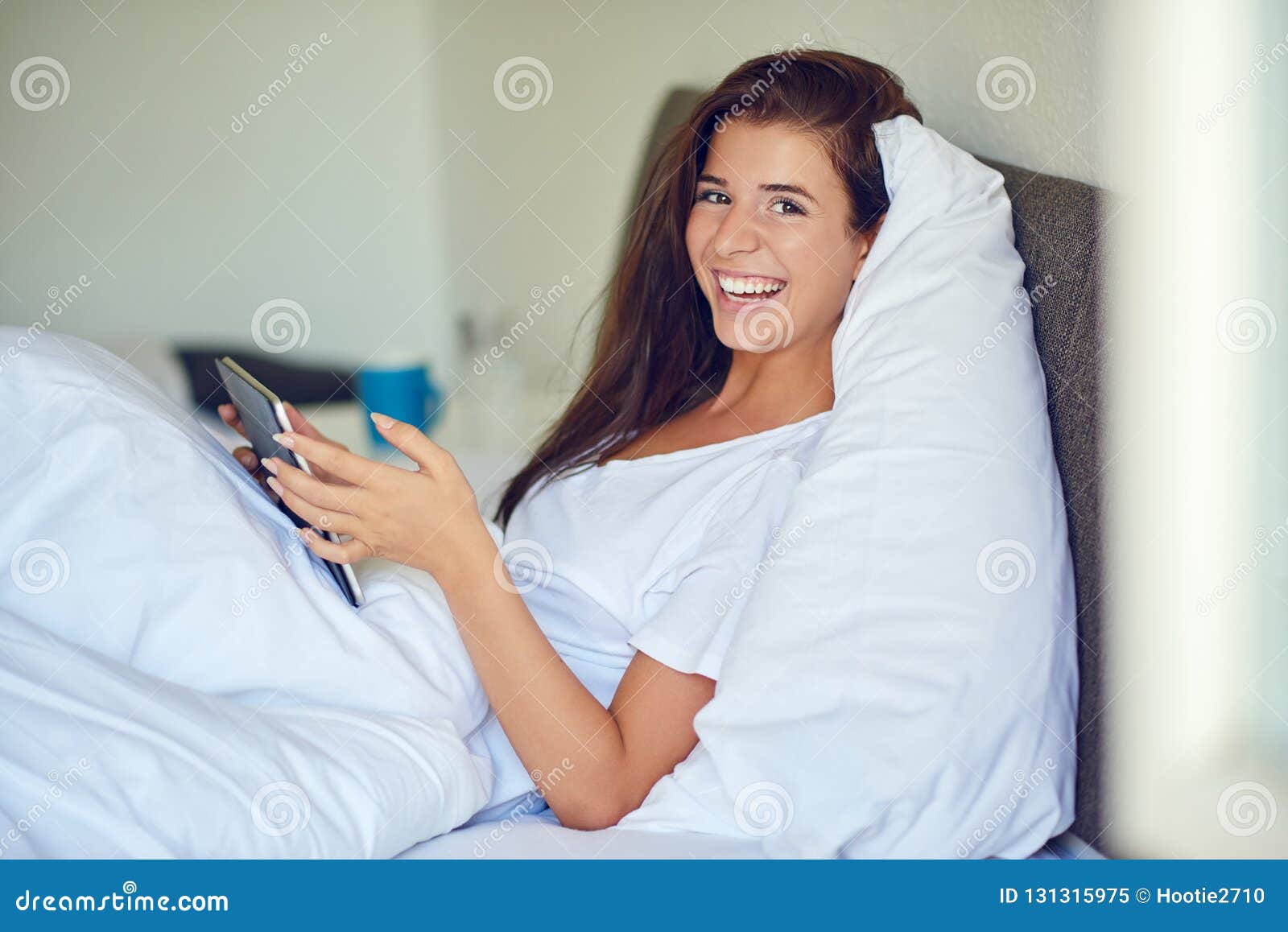 Young Pretty Woman With Long Brunette Hair Lying In Bed Stock Image