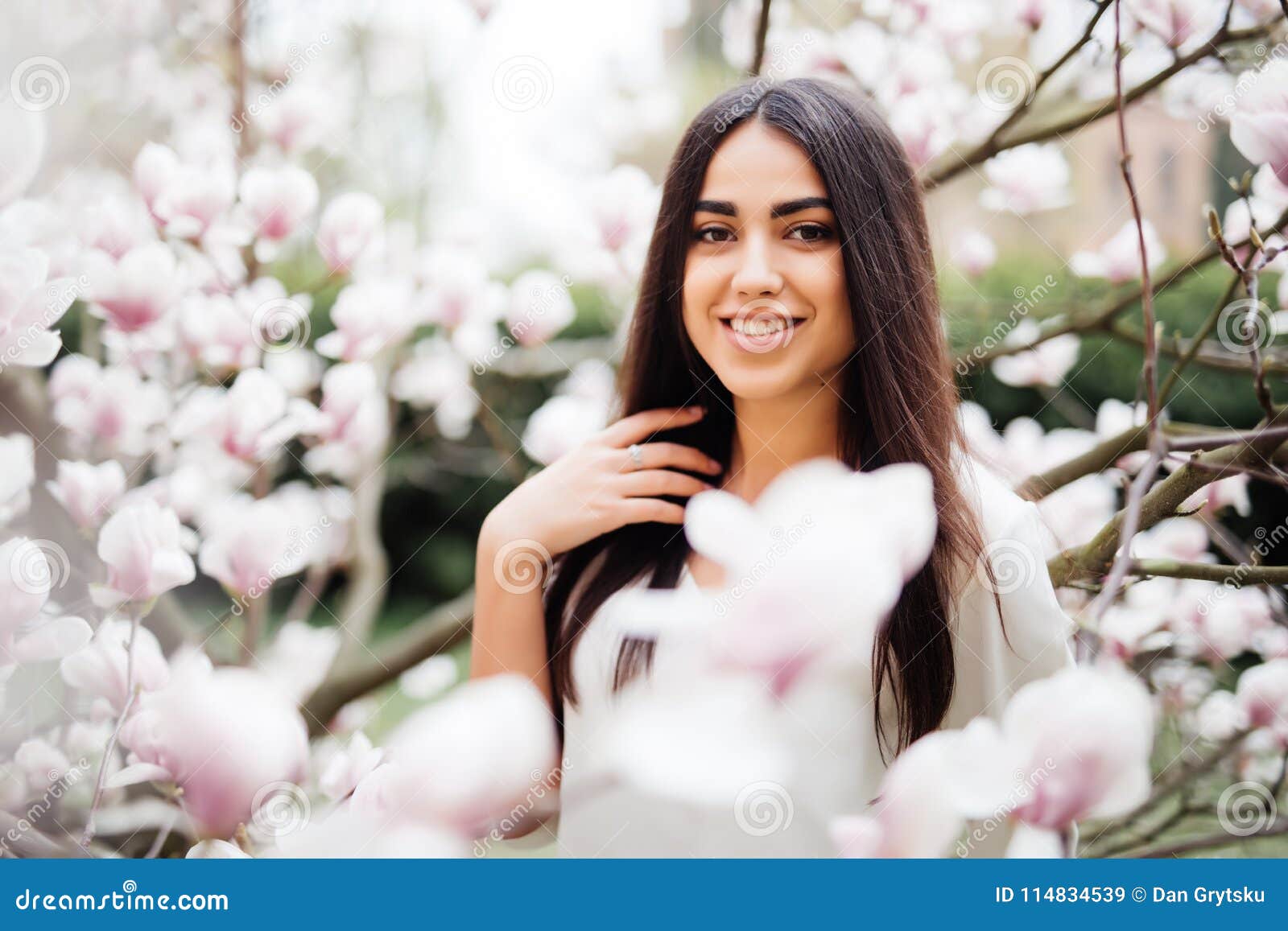 Young Pretty Woman Portrait Near Flower Of Blossom Magnolia Tree