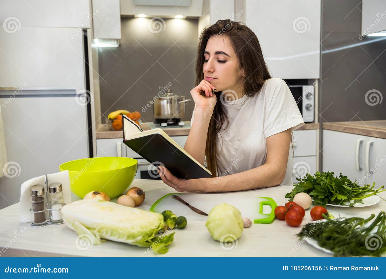 Young Pretty Woman Sits at the Kitchen Table with Different Vegetables ...