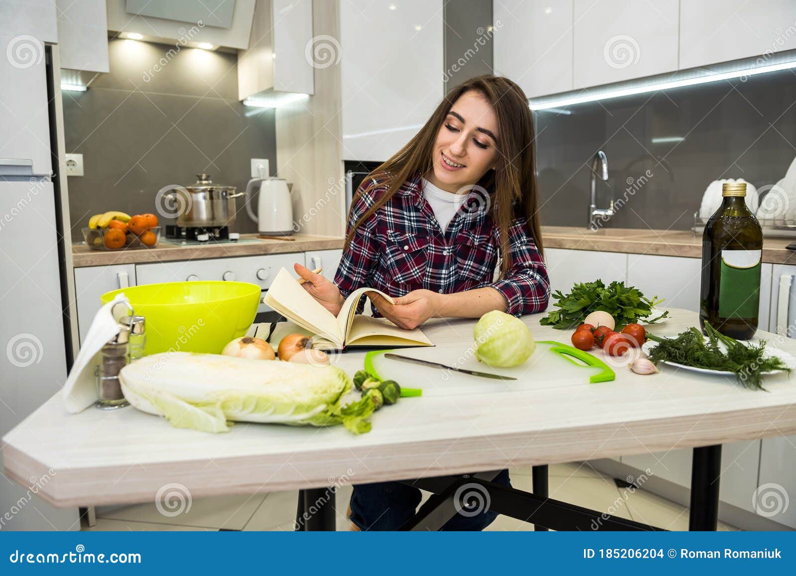 Young Pretty Woman Sits at the Kitchen Table with Different Vegetables ...