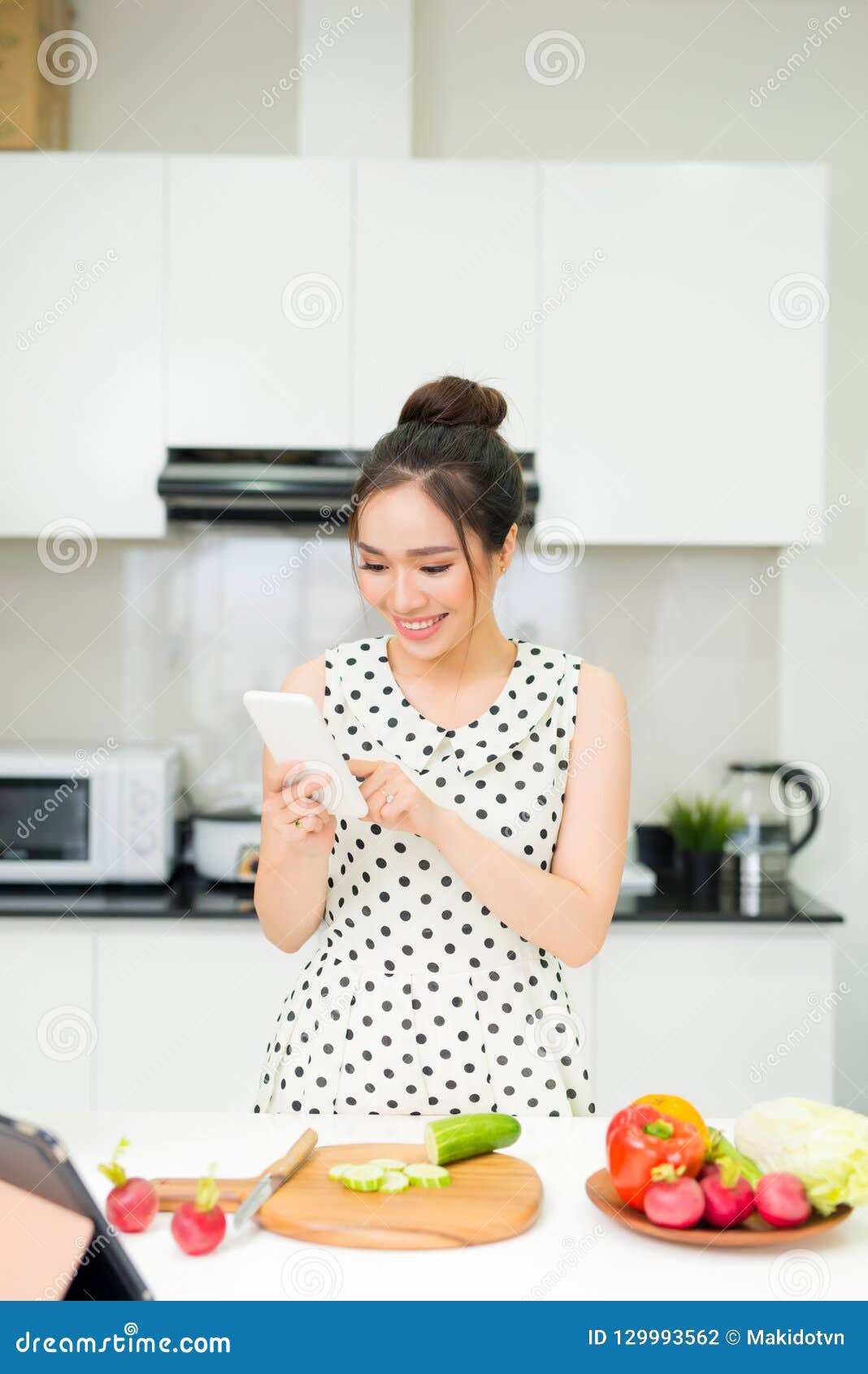 Young Pretty Woman Using Smart Phone while Cooking in Kitchen Stock ...