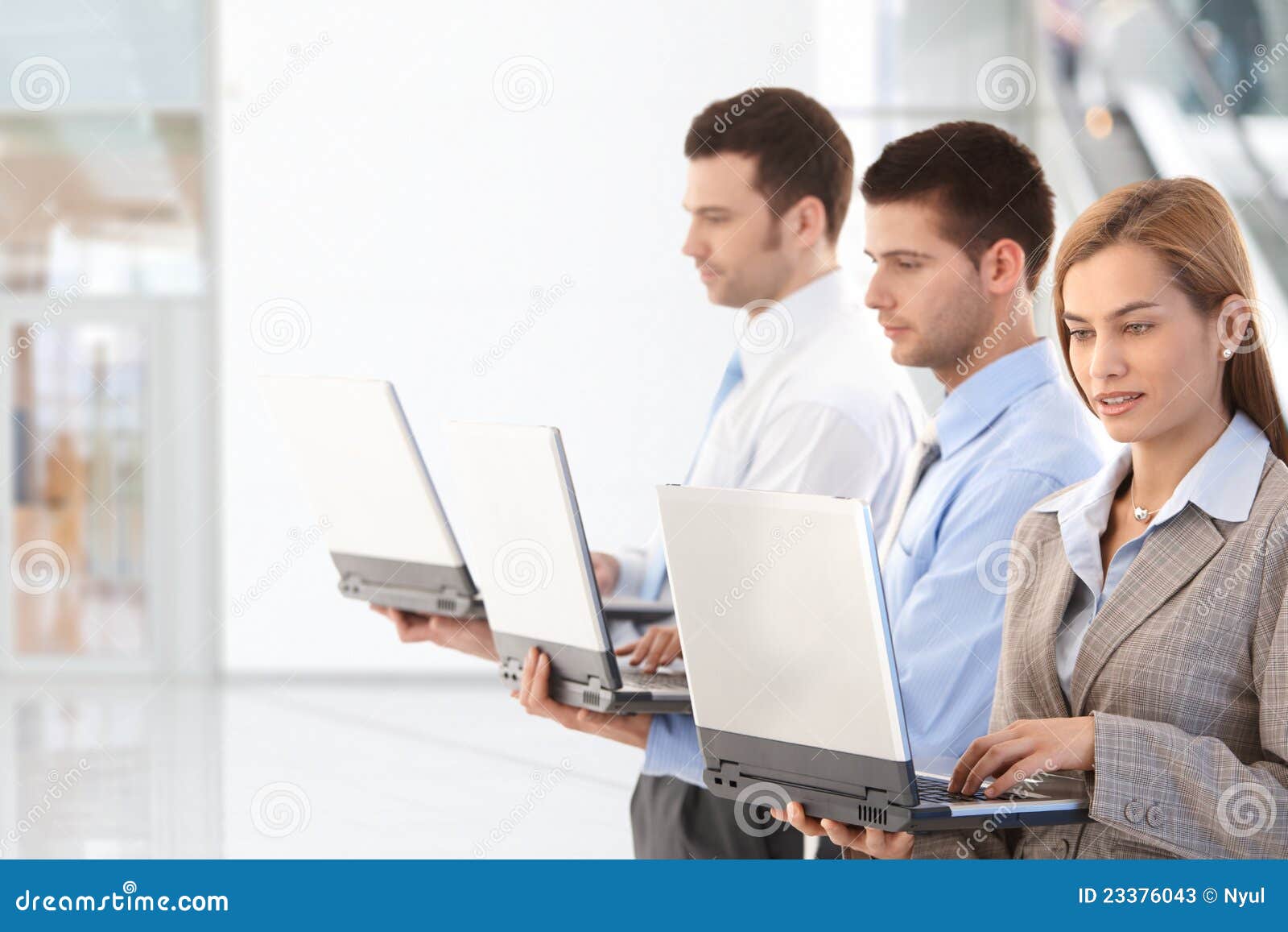 Young Professionals Using Laptop in Office Lobby Stock Image - Image of ...