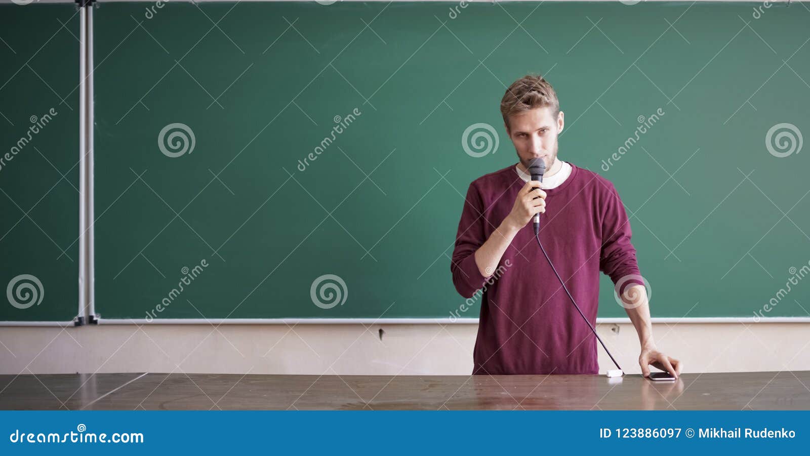 Young Professor Teacher Speaking with the Microphone in the Lecture ... Young Professor Teacher Speaking with the Microphone in the Lecture ...