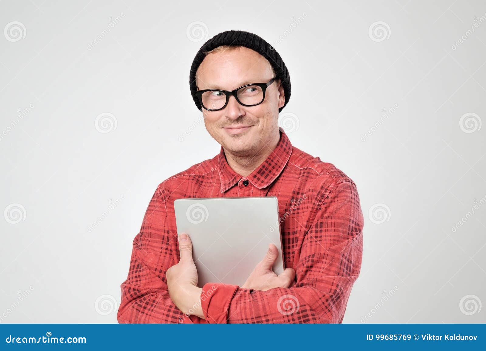 A Young Programmer in a Black Hat is Holding a Laptop in His Han Stock ...