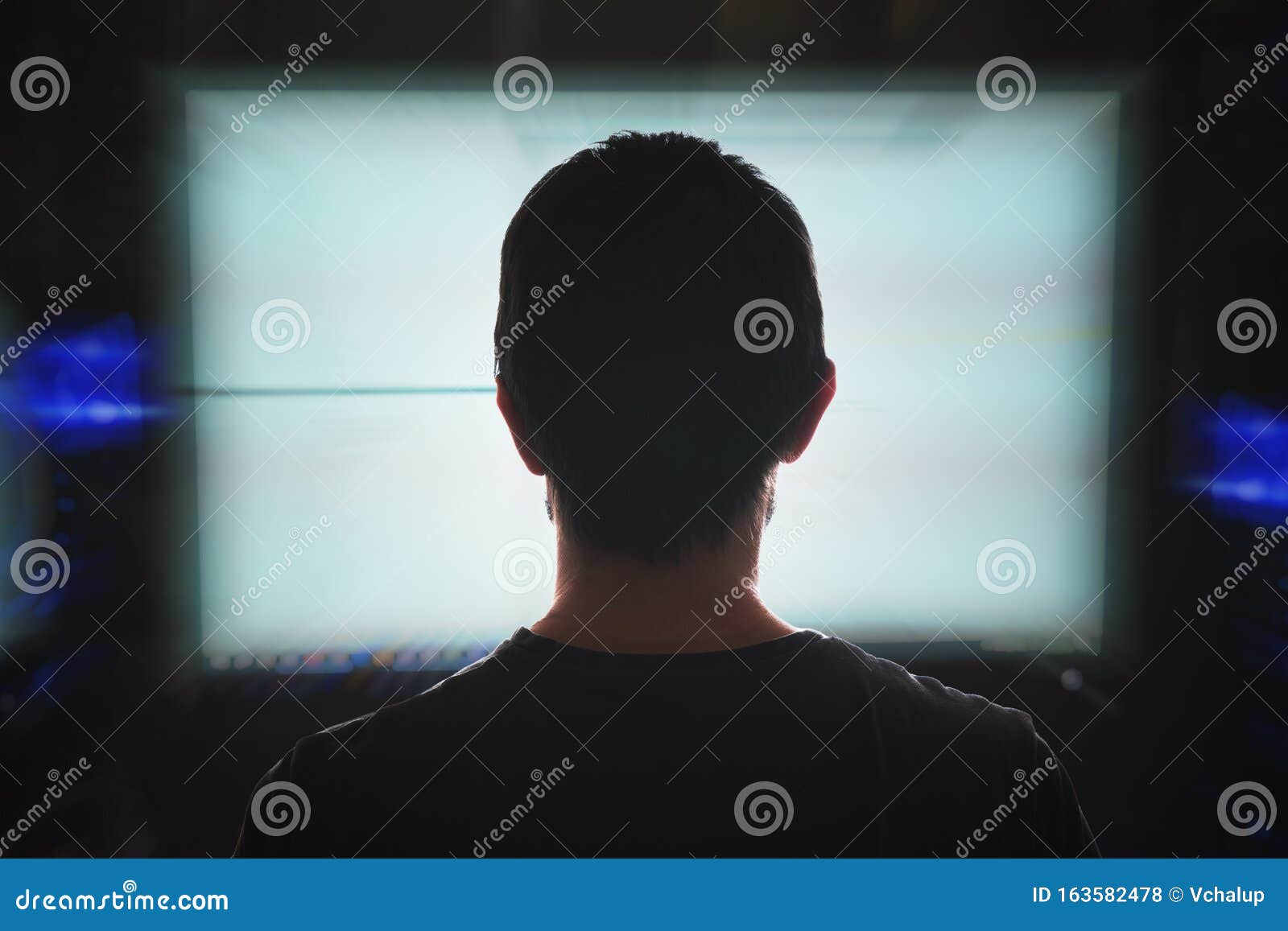 Young Programmer is Looking at Computer Screen at Night. View from ...
