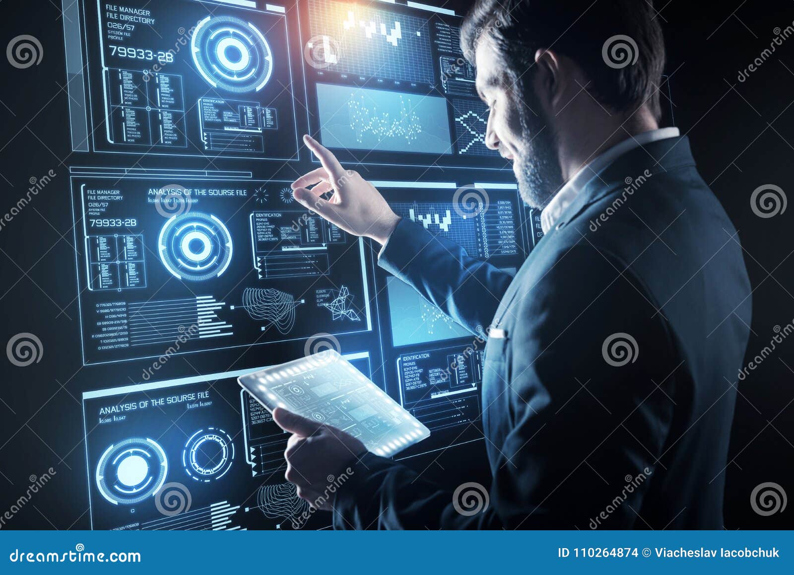 Young Programmer Looking at Tablet while Working with Futuristic ... Young Programmer Looking at Tablet while Working with Futuristic ...