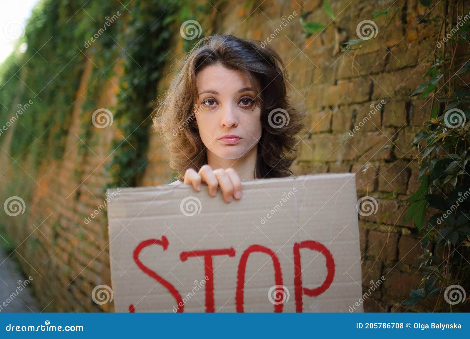Young Protesting Woman In White Shirt And Jeans Holds Protest Sign