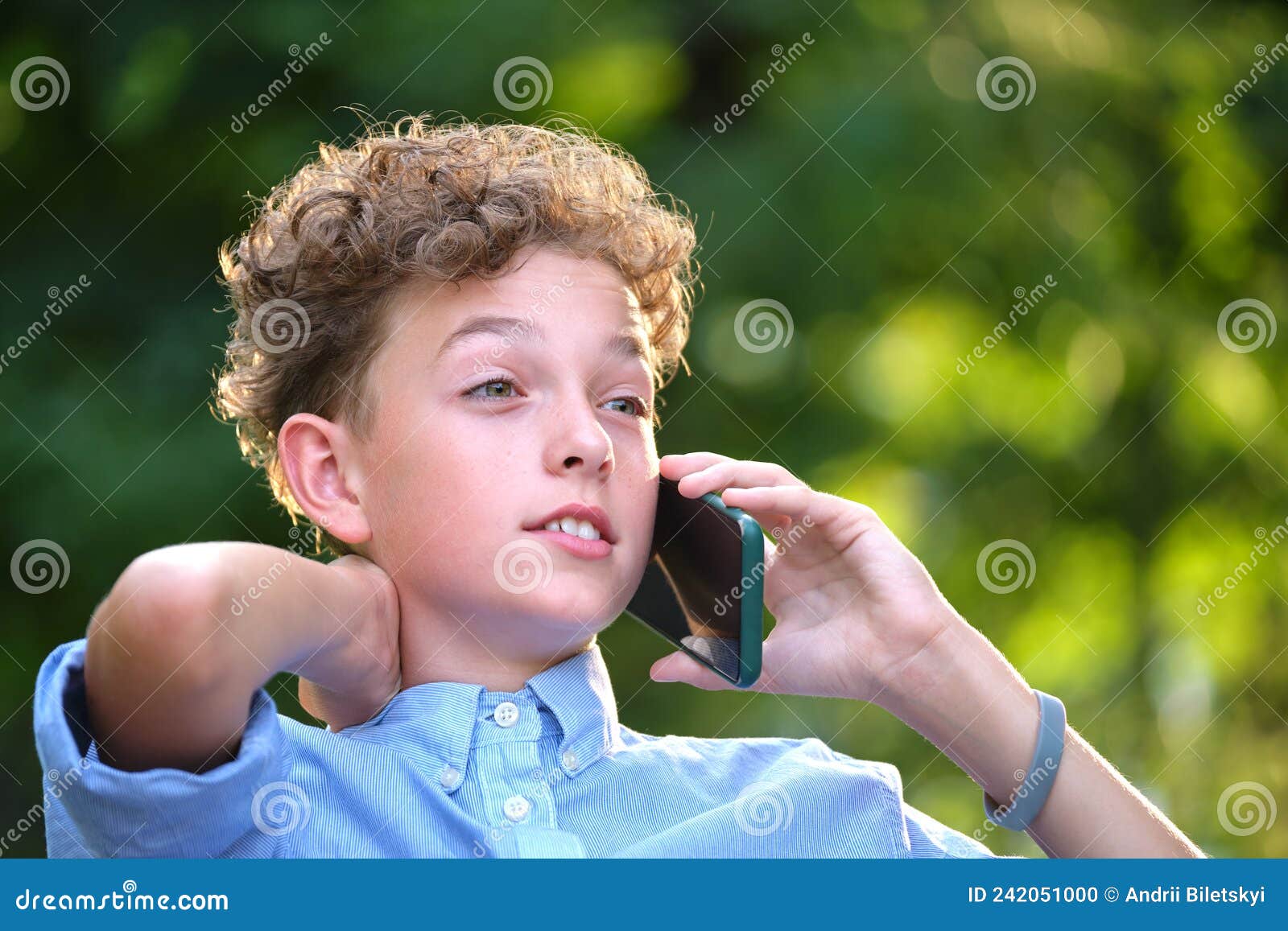 Young Puzzled Child Boy Talking on Cellphone Outdoors in Summer Park ...
