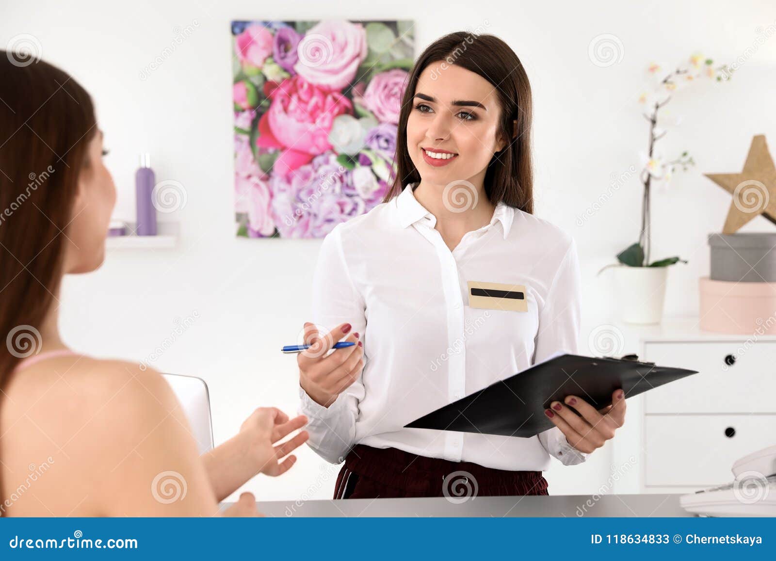 Young Receptionist Working with Client at Desk Stock Image - Image of ...