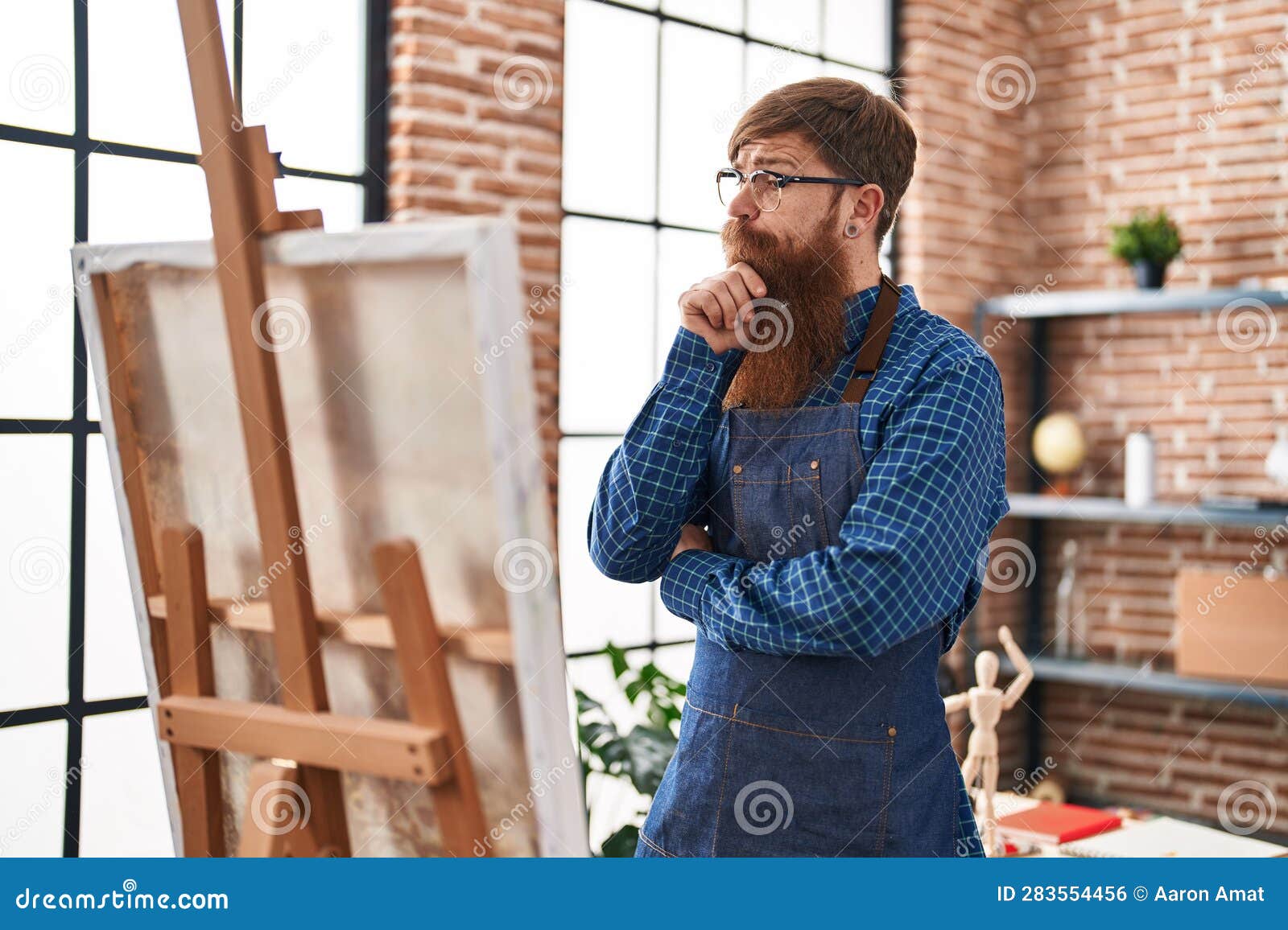 Young Redhead Man Artist Looking Draw with Doubt Expression at Art ...