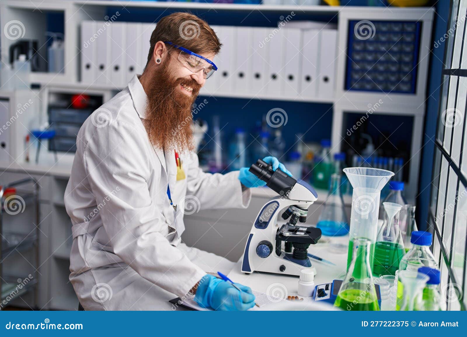Young Redhead Man Scientist Using Microscope Writing Report Working at ...