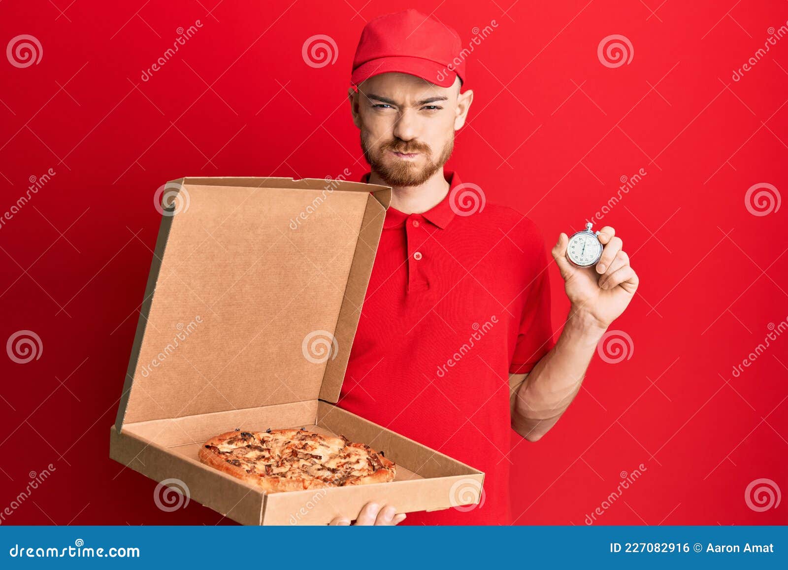Young Redhead Man Wearing Delivery Uniform Holding Pizza Box And